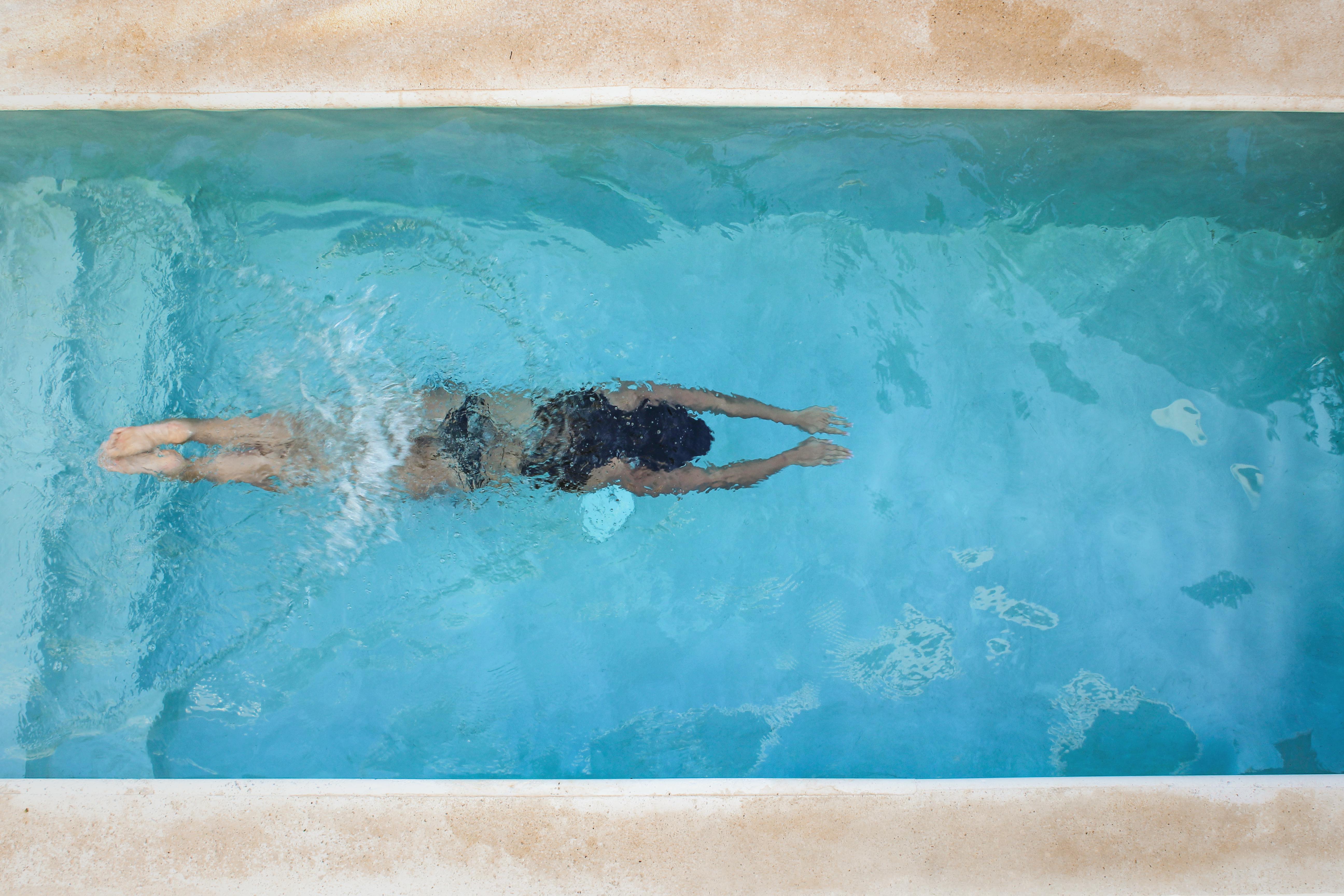 Top View of a Person Diving into the Swimming Pool · Free Stock Photo