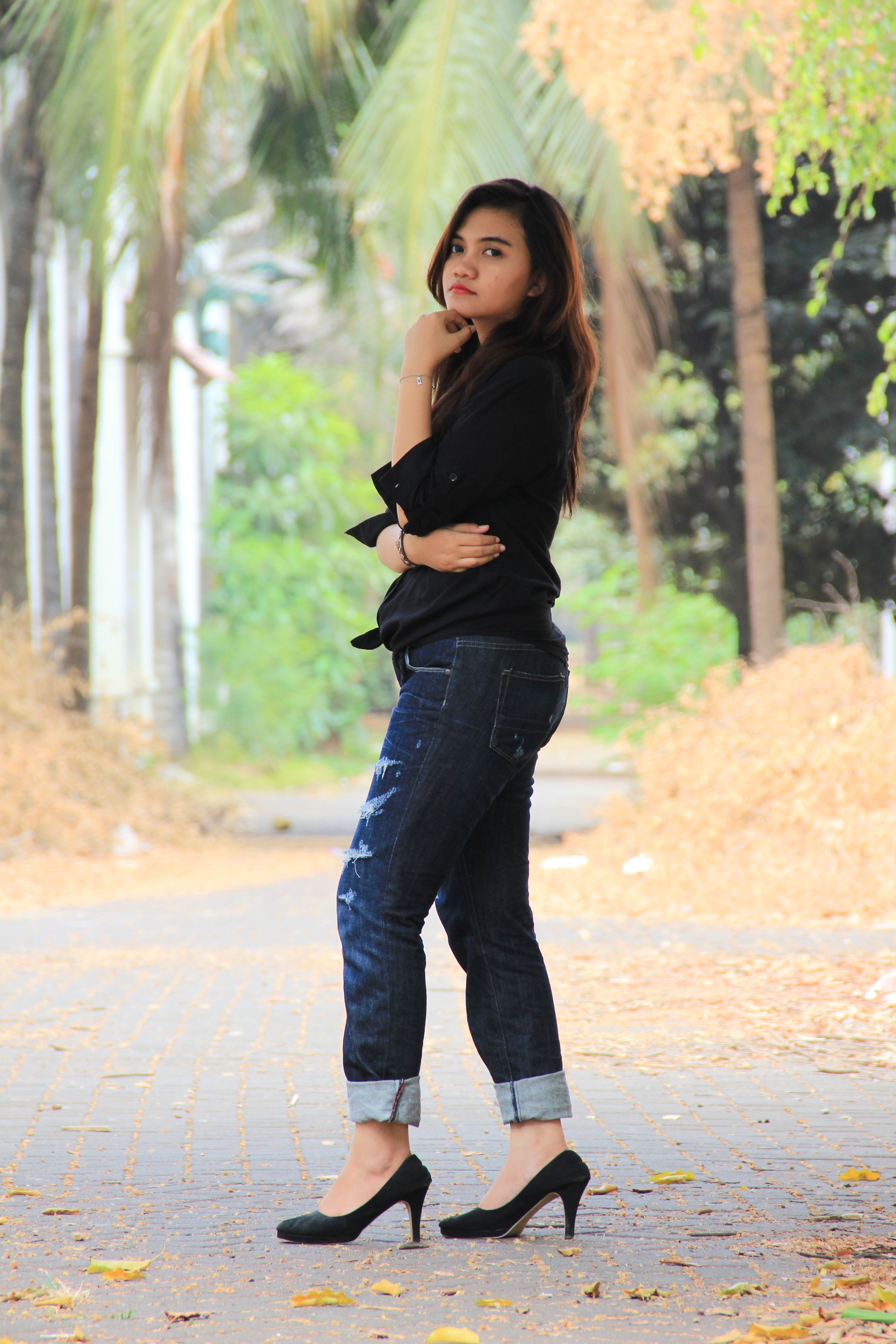 Woman in Black Three Fourths Shirt and Blue Denim Jeans Standing on ...