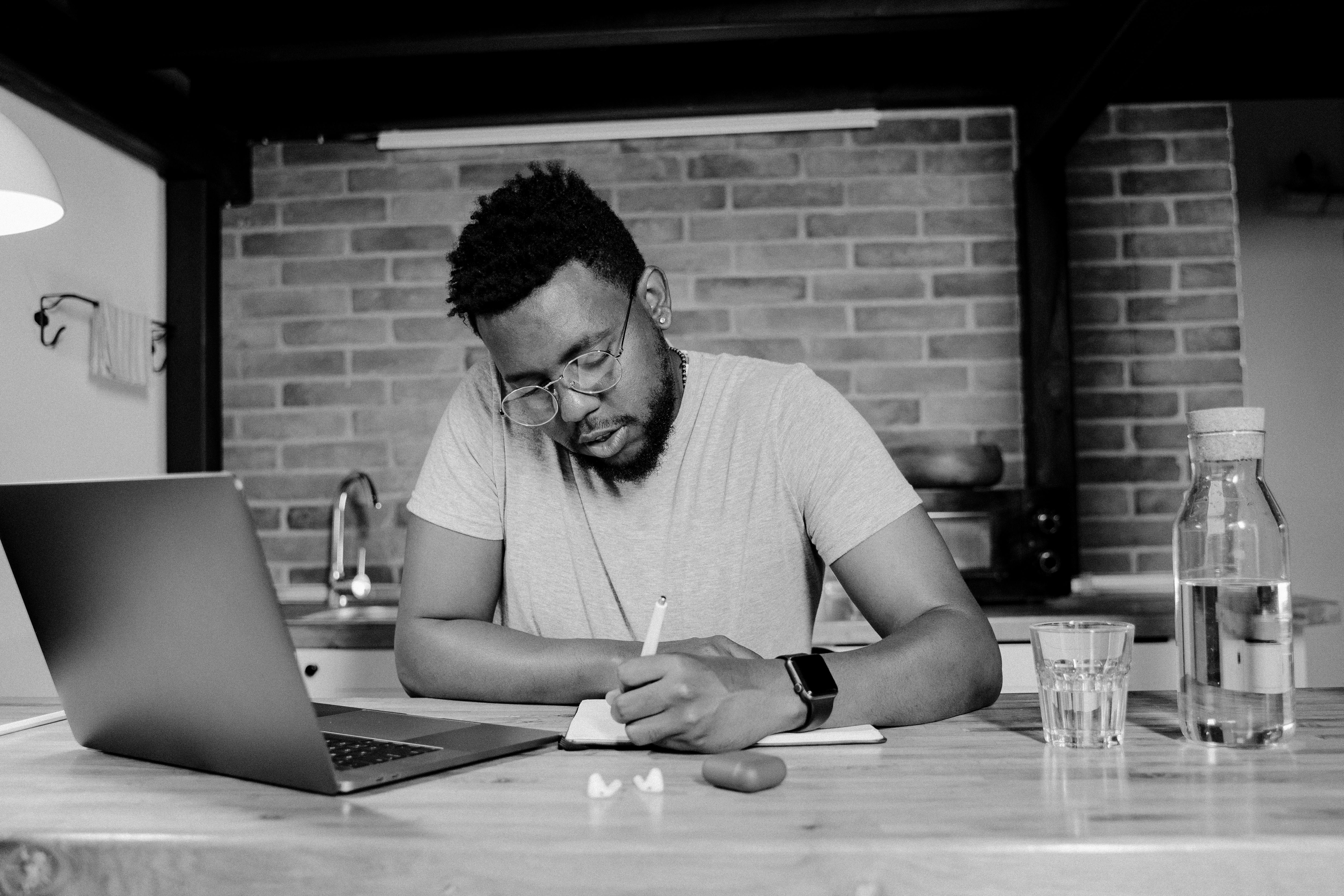 Grayscale Photo of Man Writing · Free Stock Photo