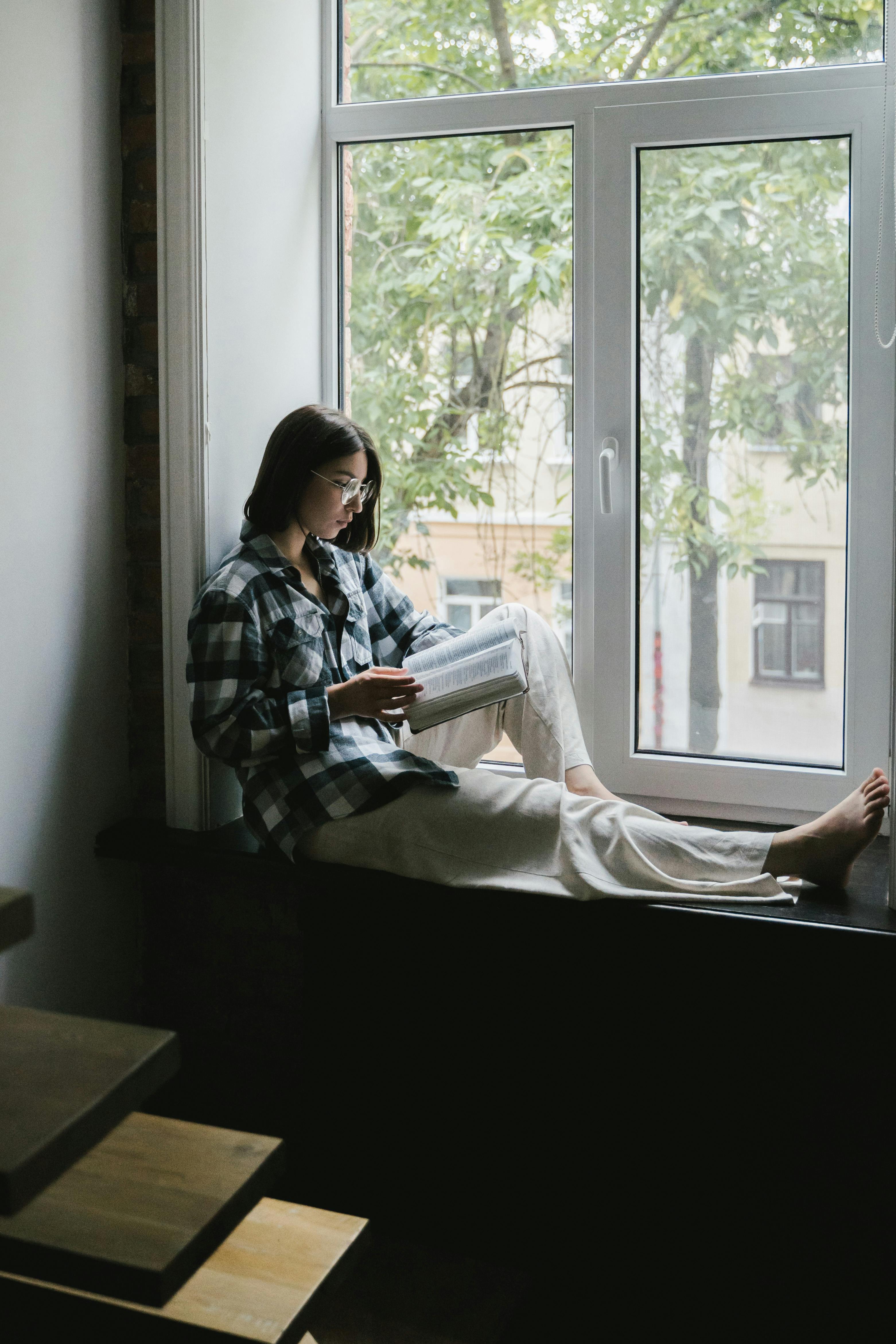 Back View of Woman Sitting Reading a Book · Free Stock Photo