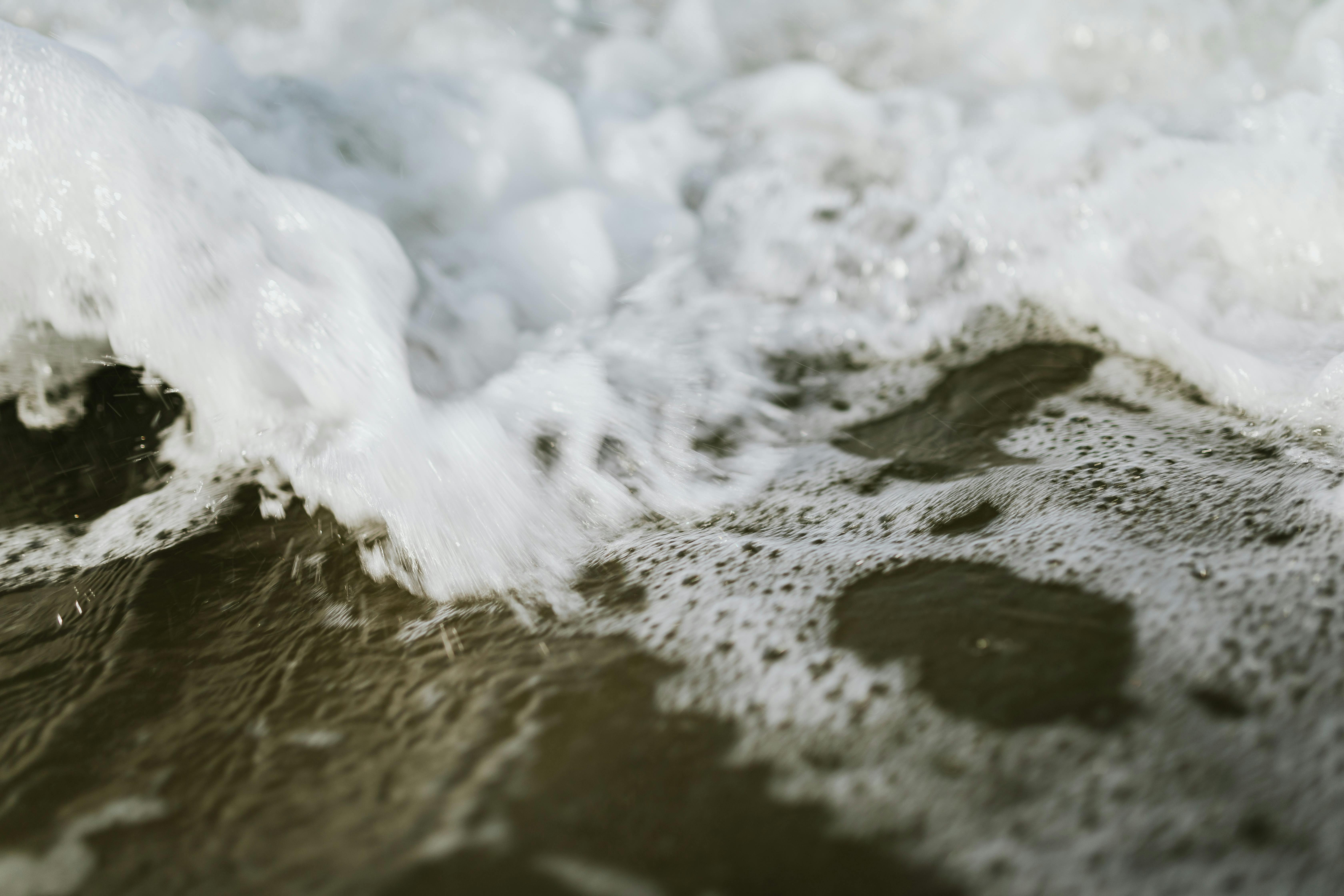 Thick Sea Foam Floating on Water · Free Stock Photo