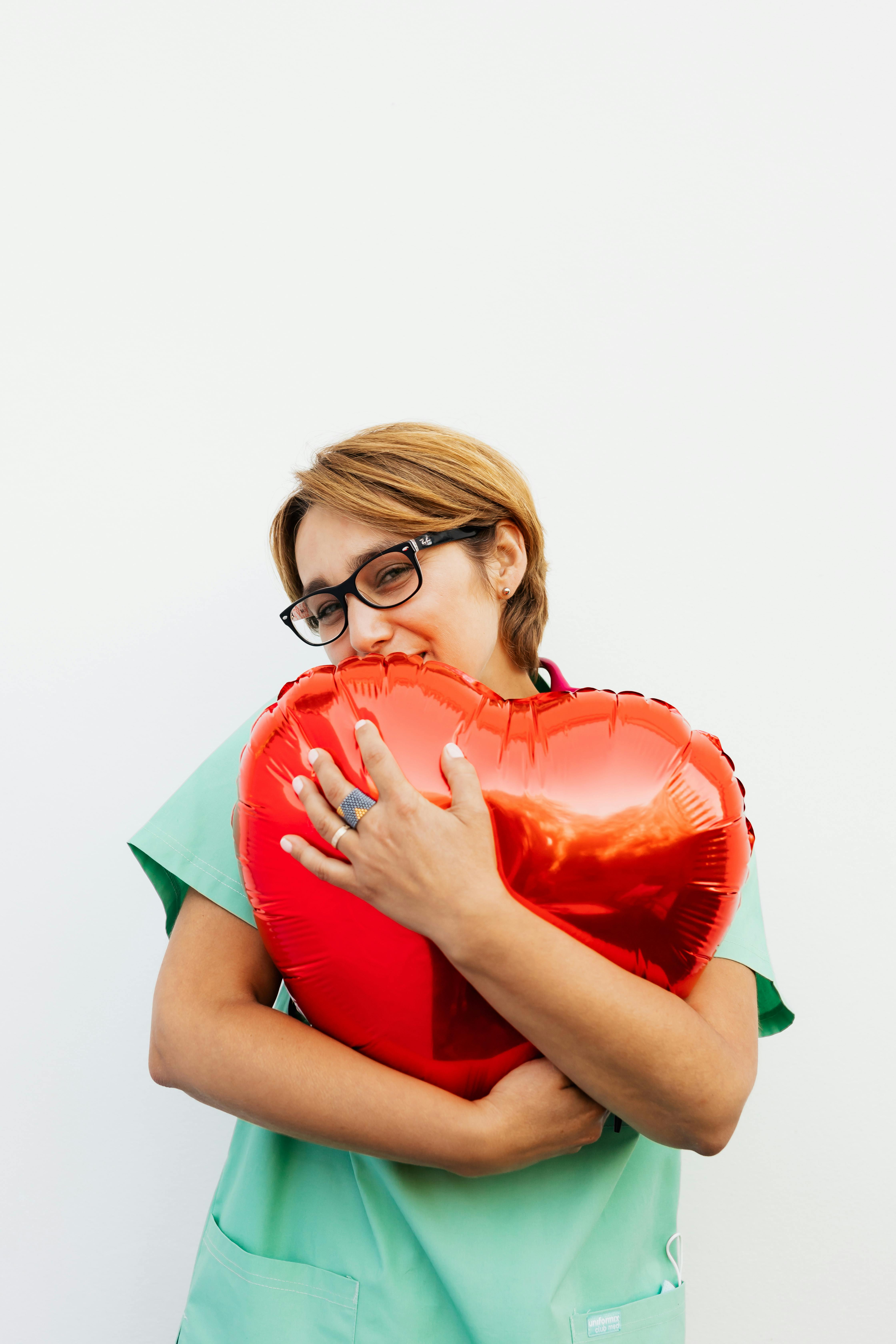 Woman Hugging a Red Heart Balloon · Free Stock Photo