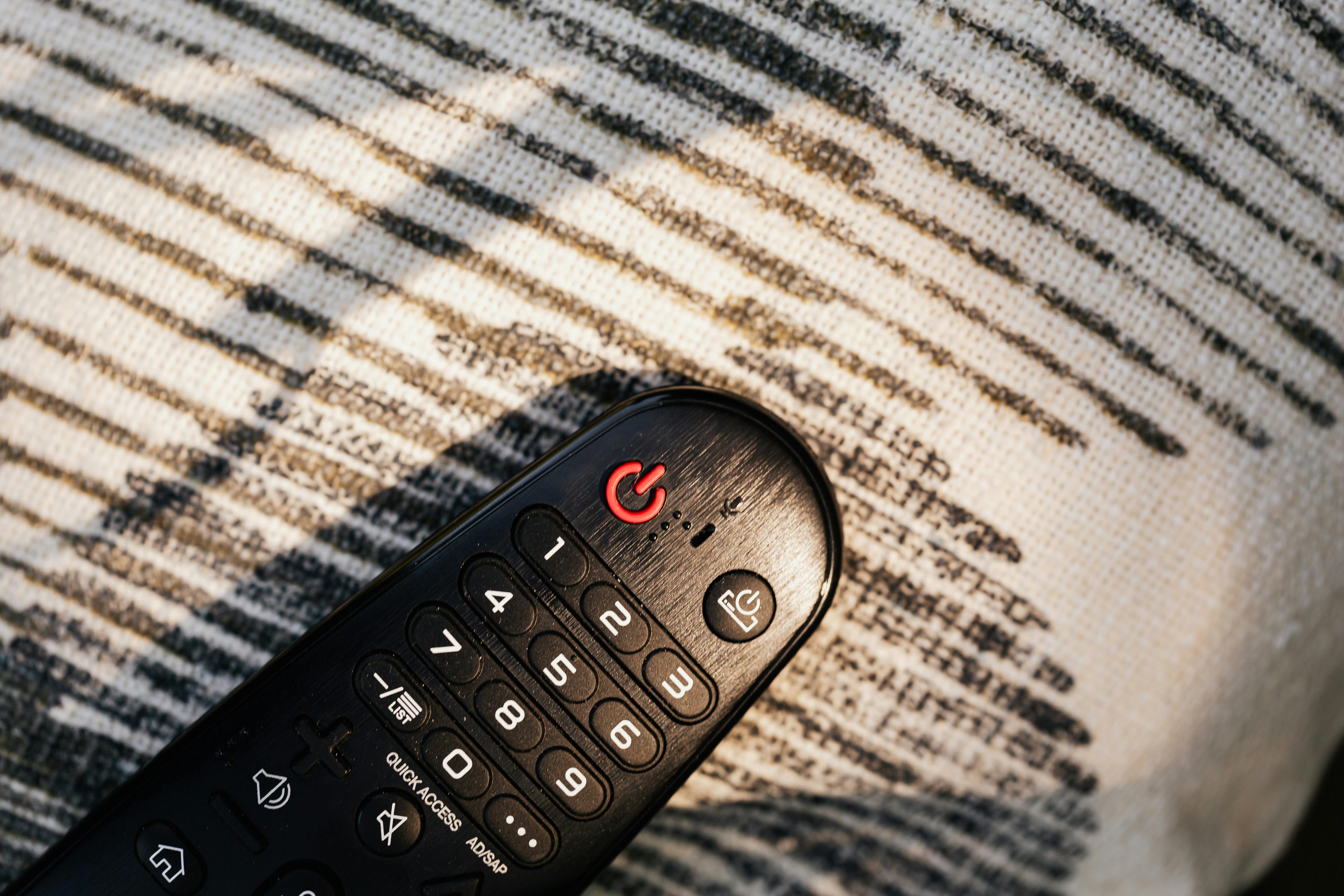 Person Holding a Black Remote Control · Free Stock Photo
