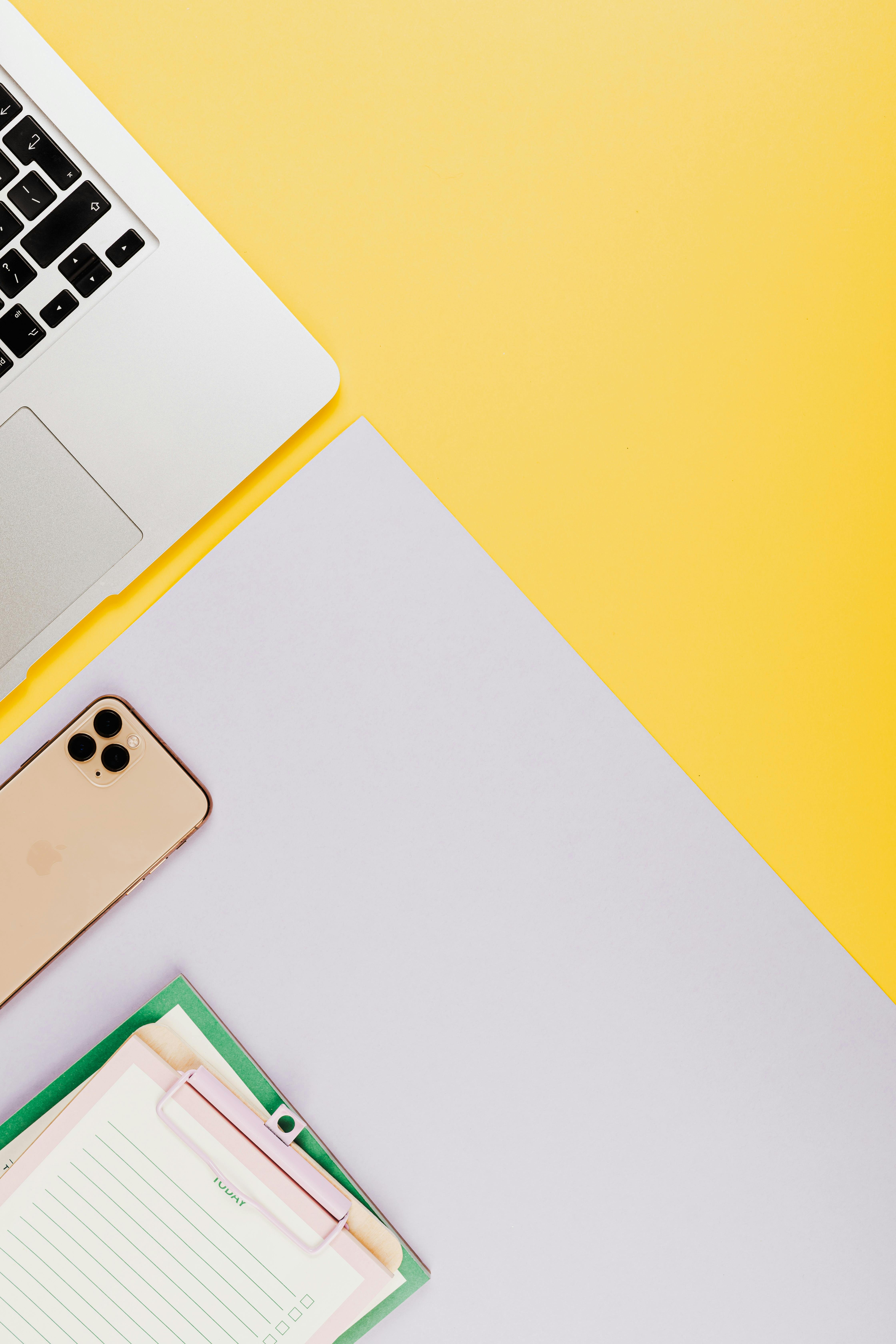 Smartphone Beside Laptop and Notepad on Clipboard · Free Stock Photo