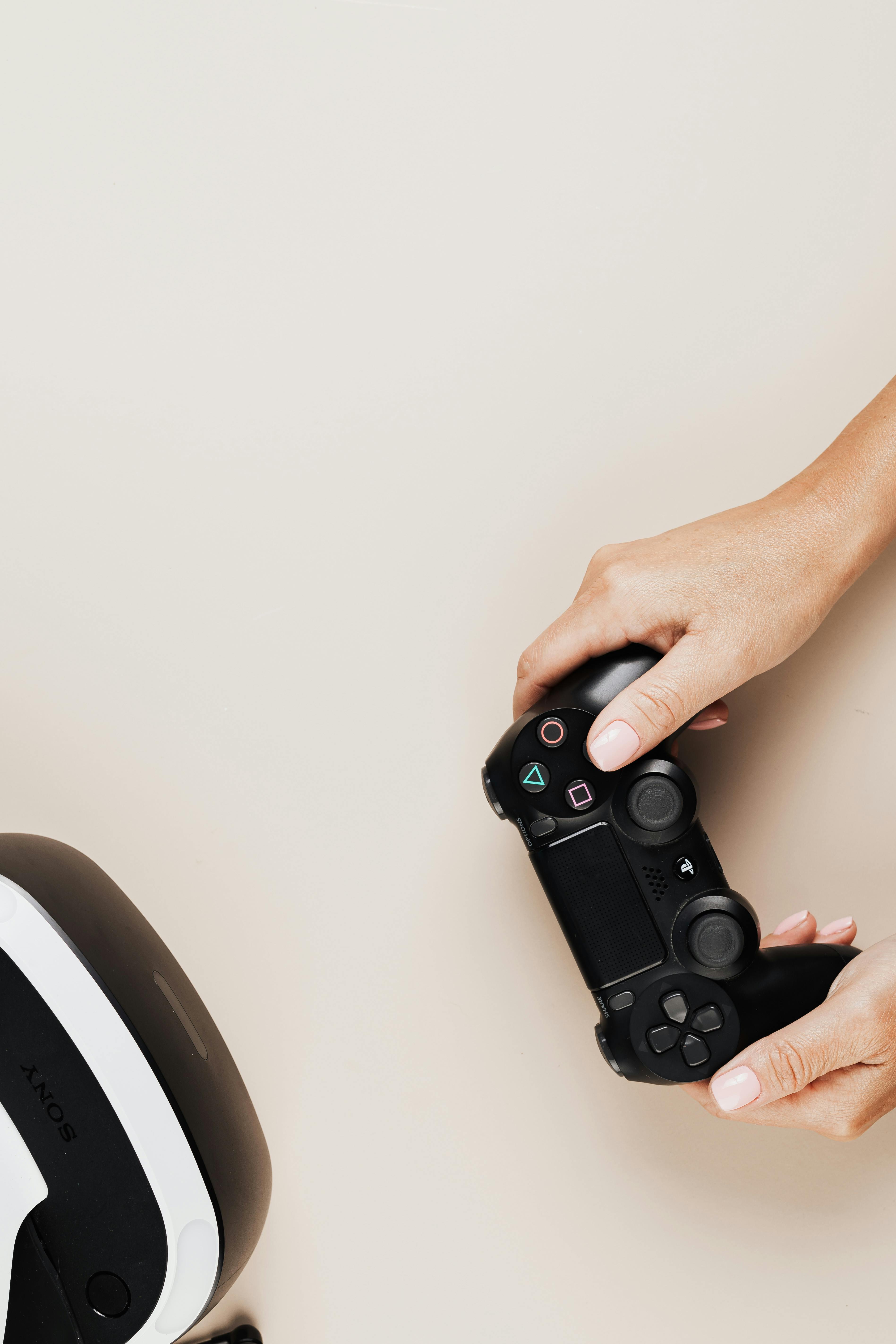 Flat Lay Shot of a Person Holding a Video Game Controller Near a VR ...
