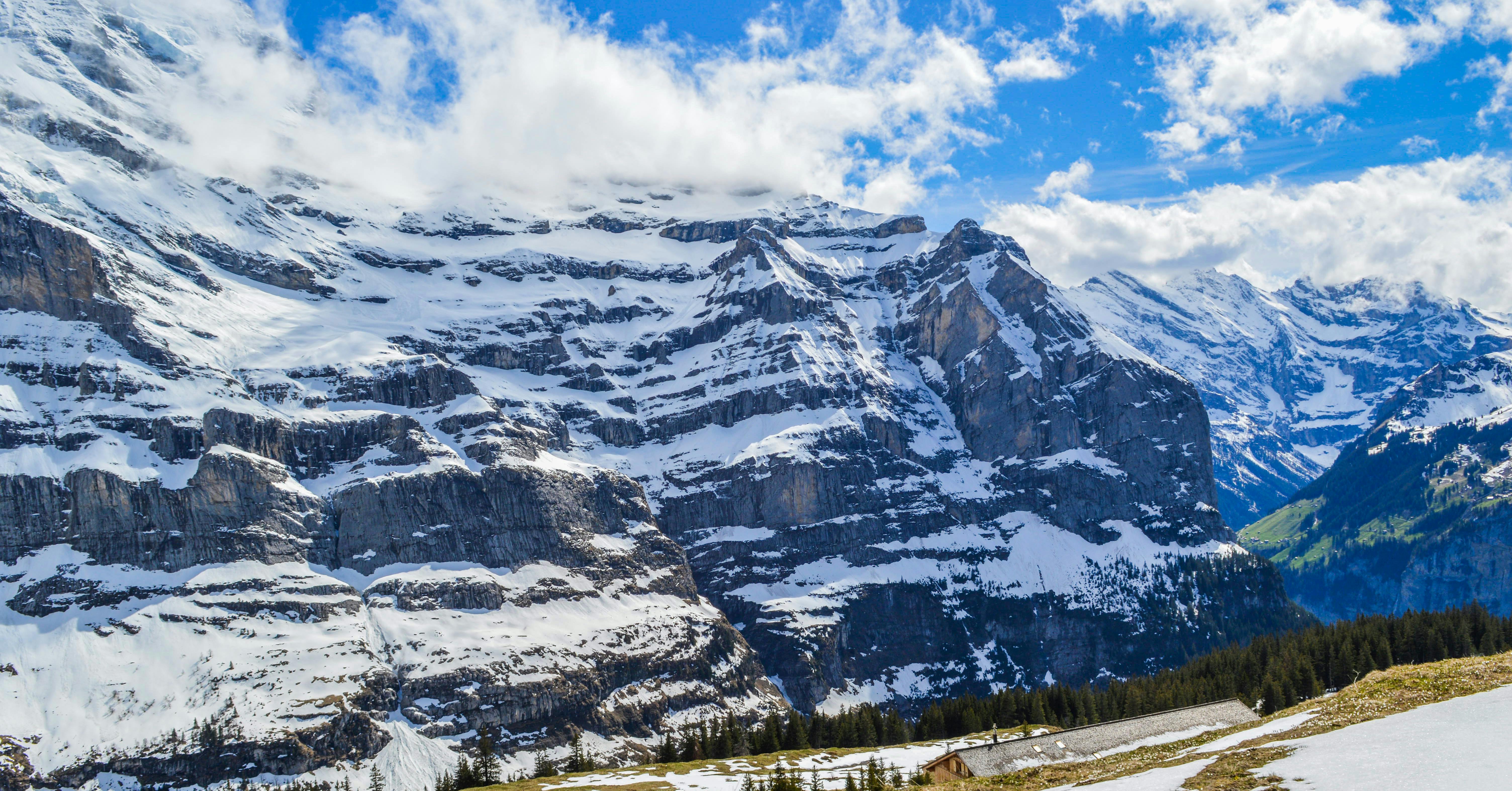 High snowy ridge under blue cloudy sky · Free Stock Photo