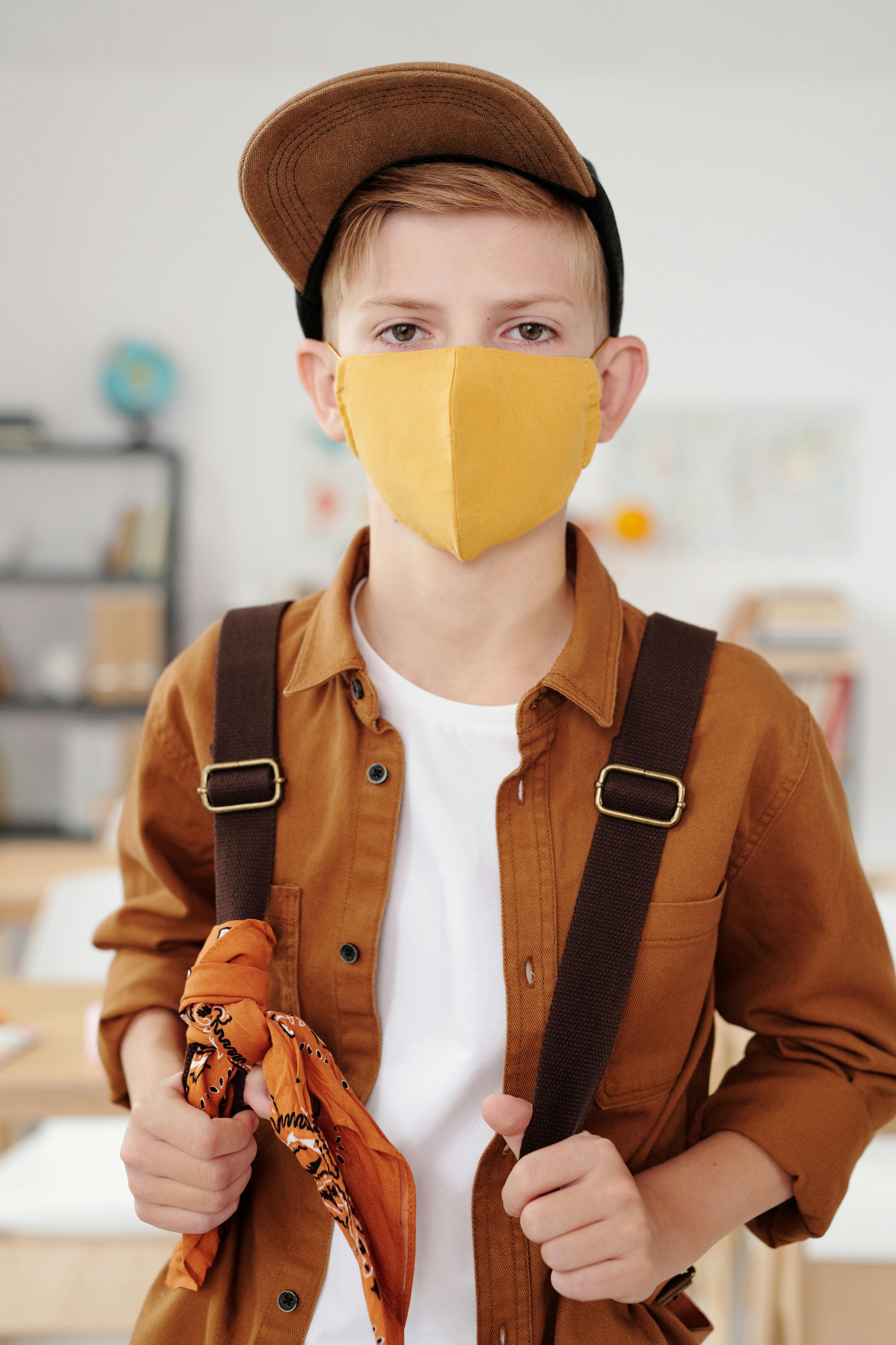 Boy in Brown Long Sleeves With Face Mask · Free Stock Photo