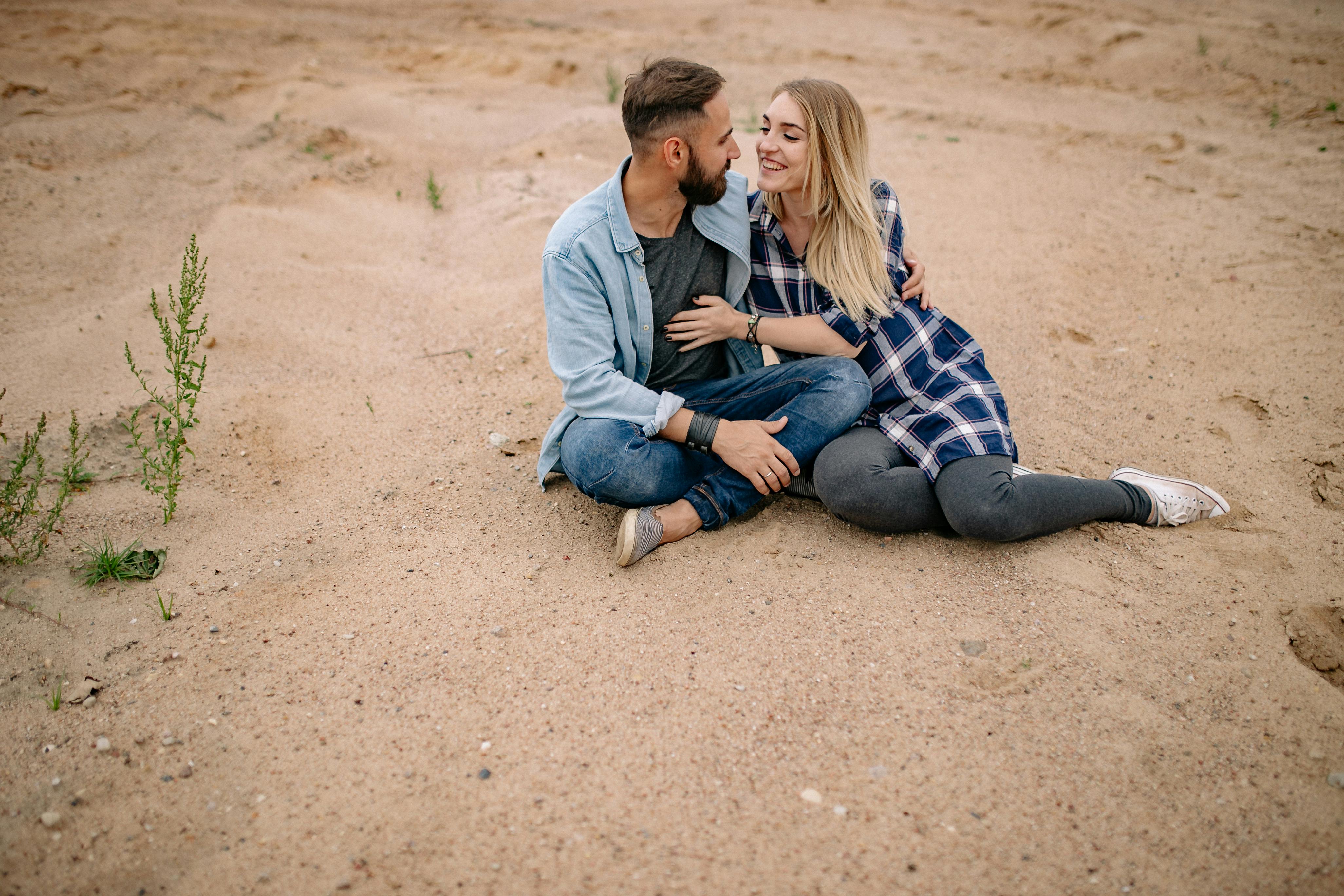 Man Sitting on Sand while Woman Lying on his Lap · Free Stock Photo