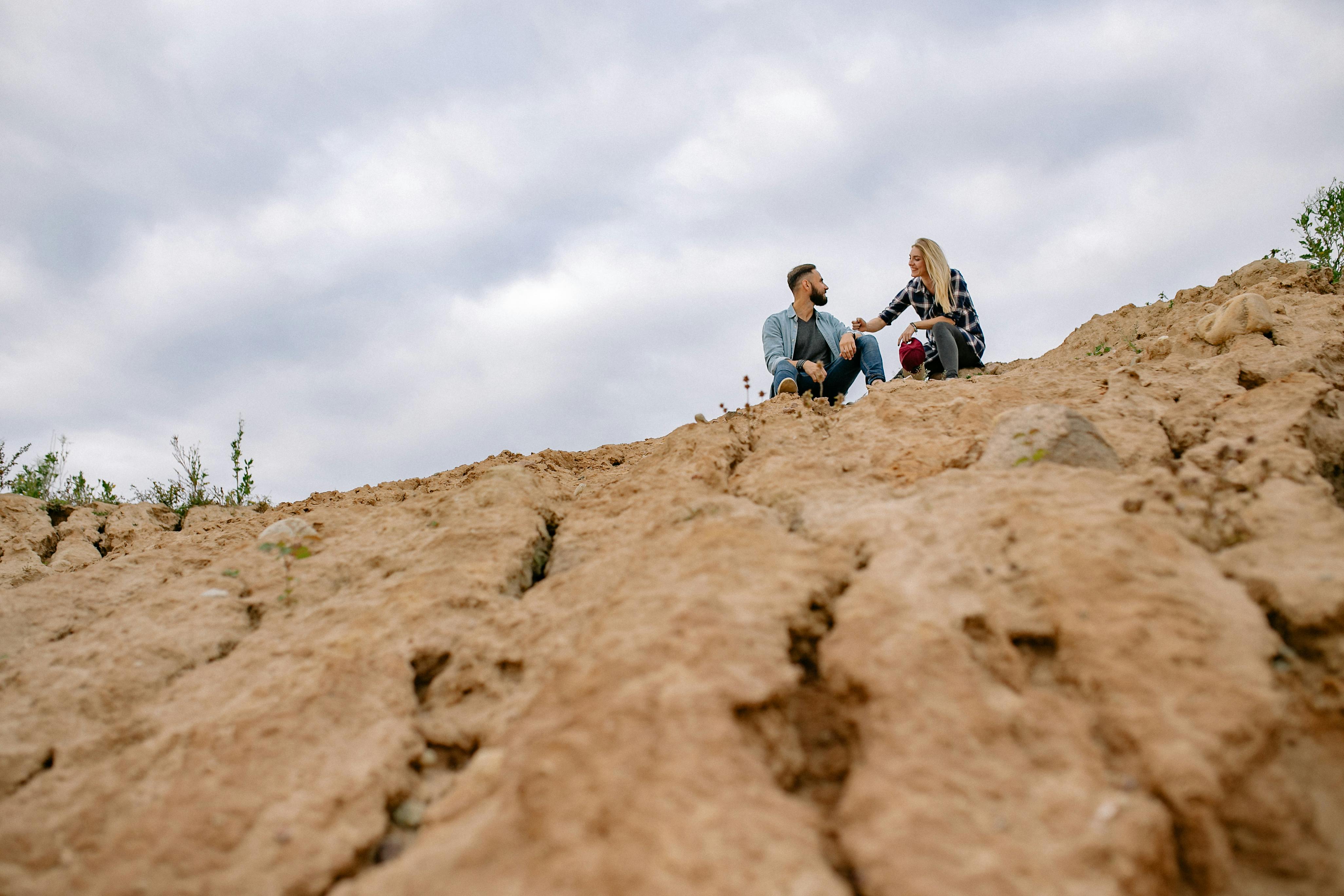 Couple Sitting on Cliff Talking · Free Stock Photo