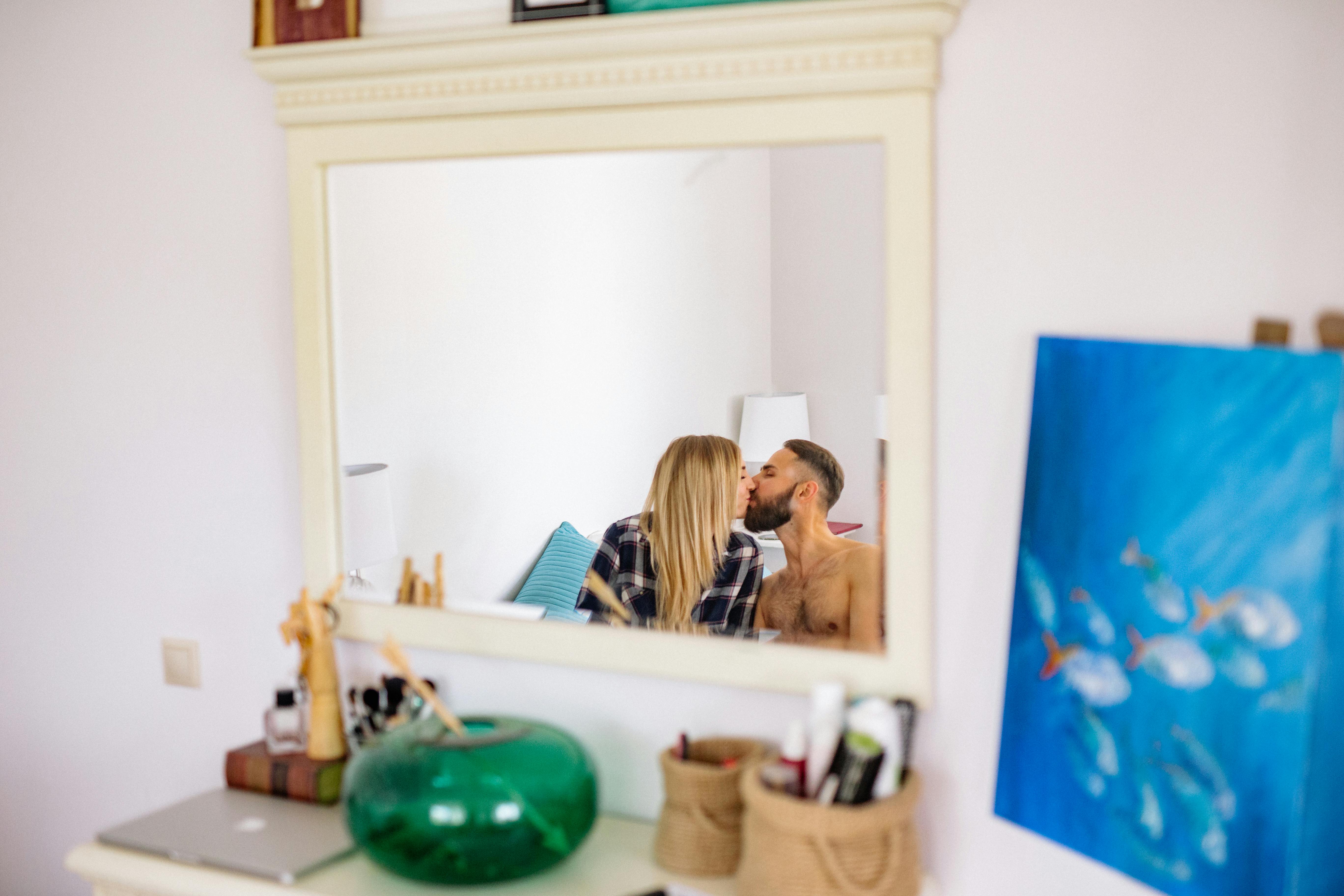 Mirror Reflection of a Couple Kissing in a Home Interior · Free Stock Photo
