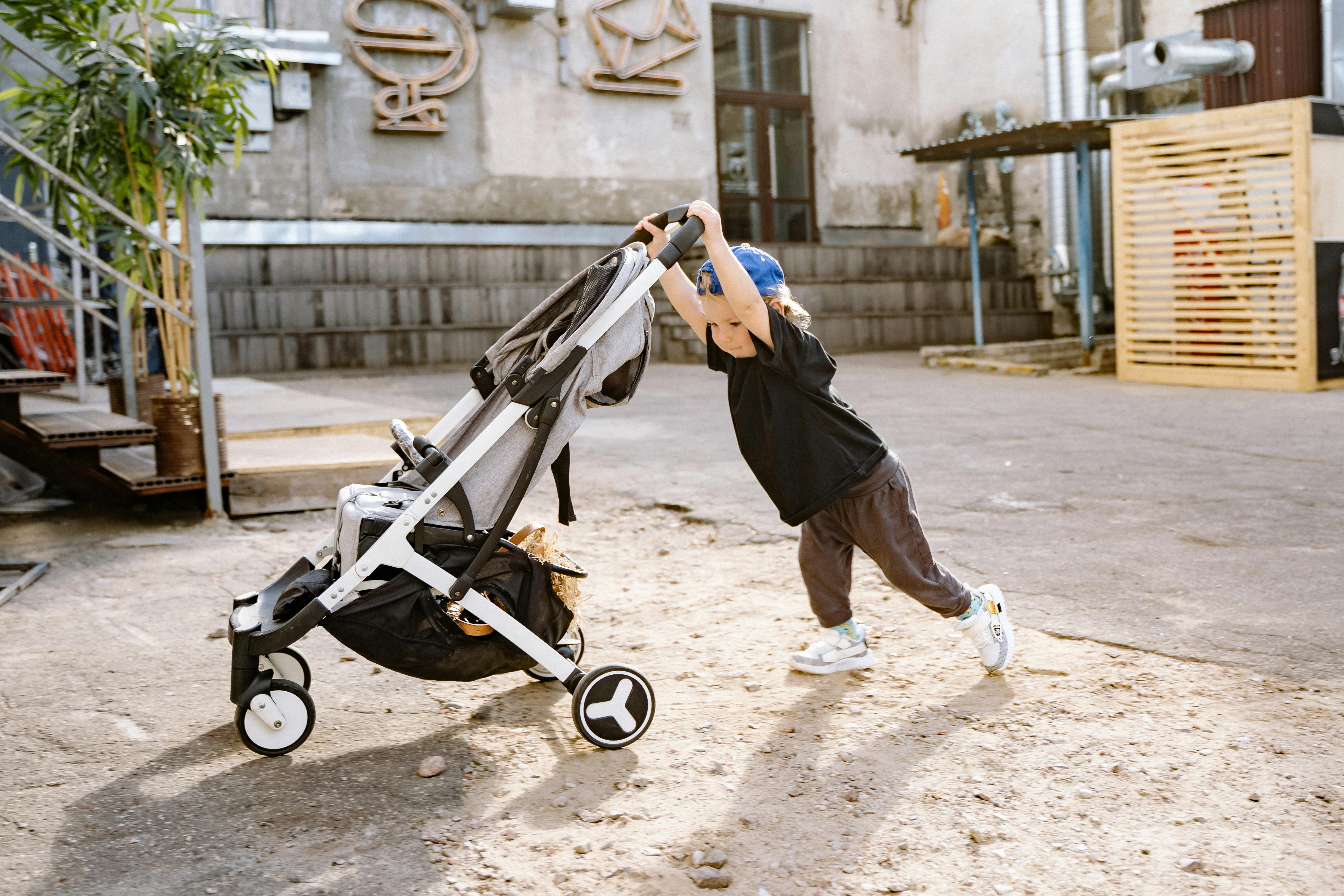 Small Boy Pushing Stroller · Free Stock Photo
