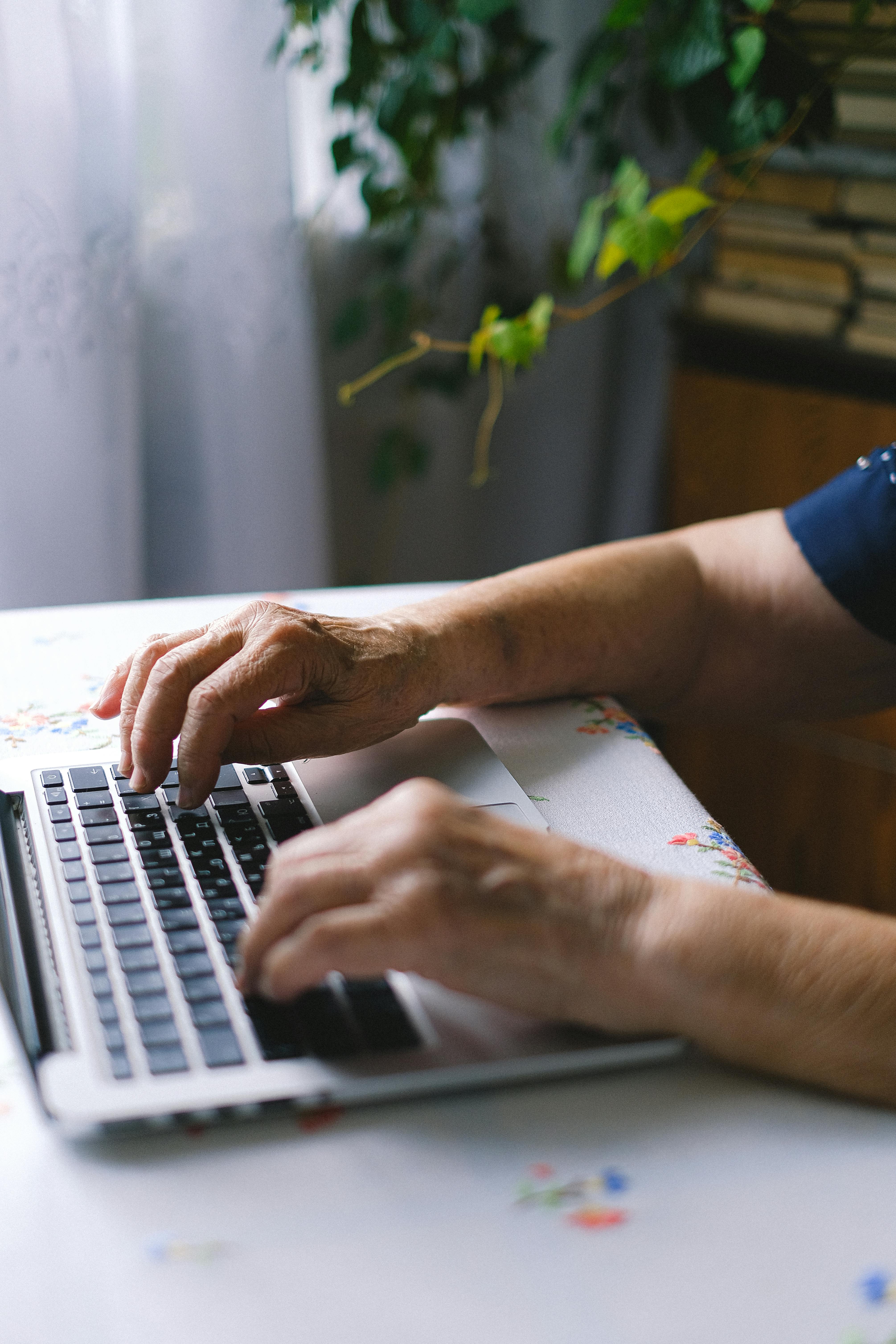 A Person Using a Laptop on the Table · Free Stock Photo