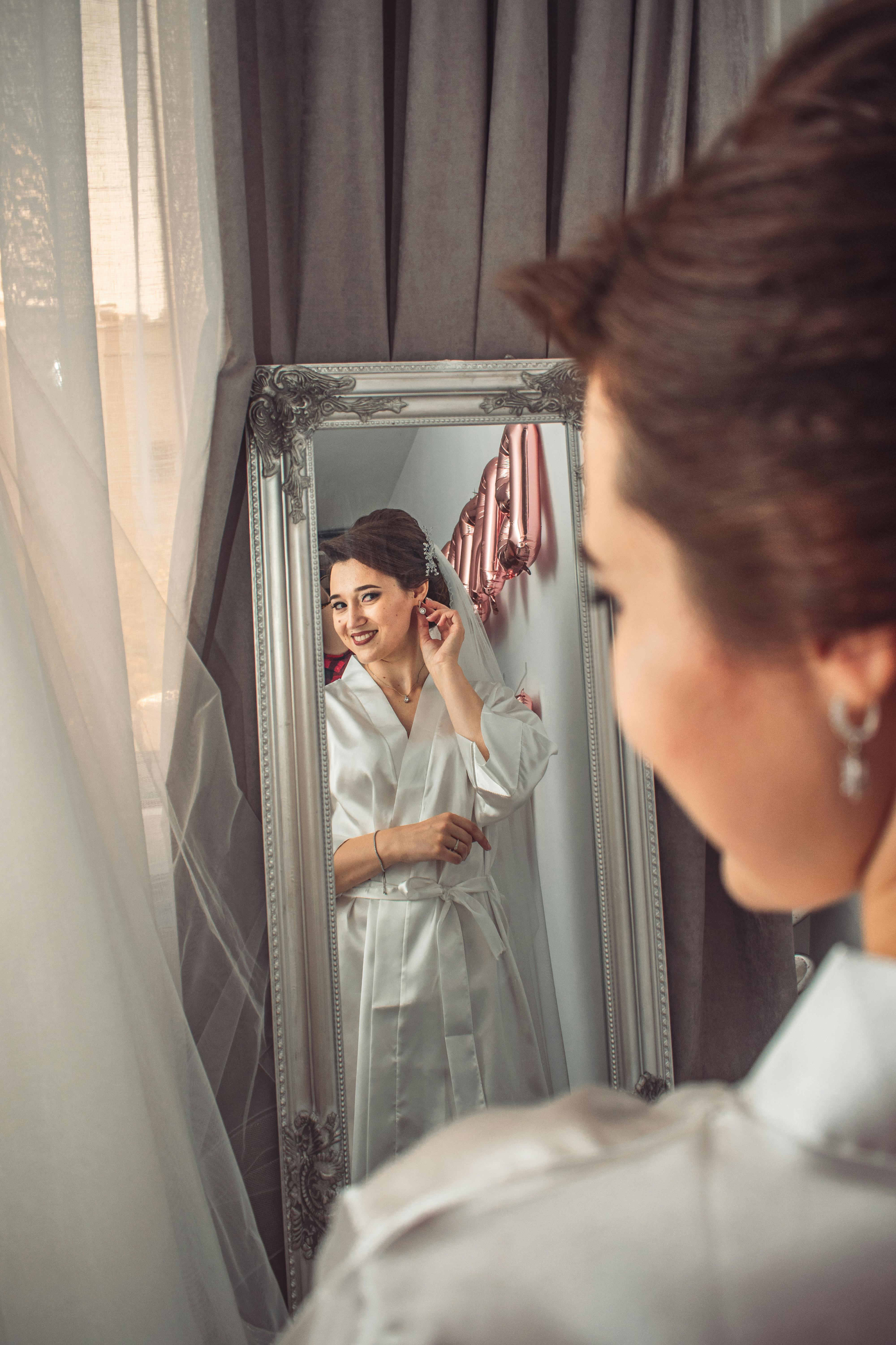 A Woman in White Robe Standing Beside Sheer Curtain · Free Stock Photo