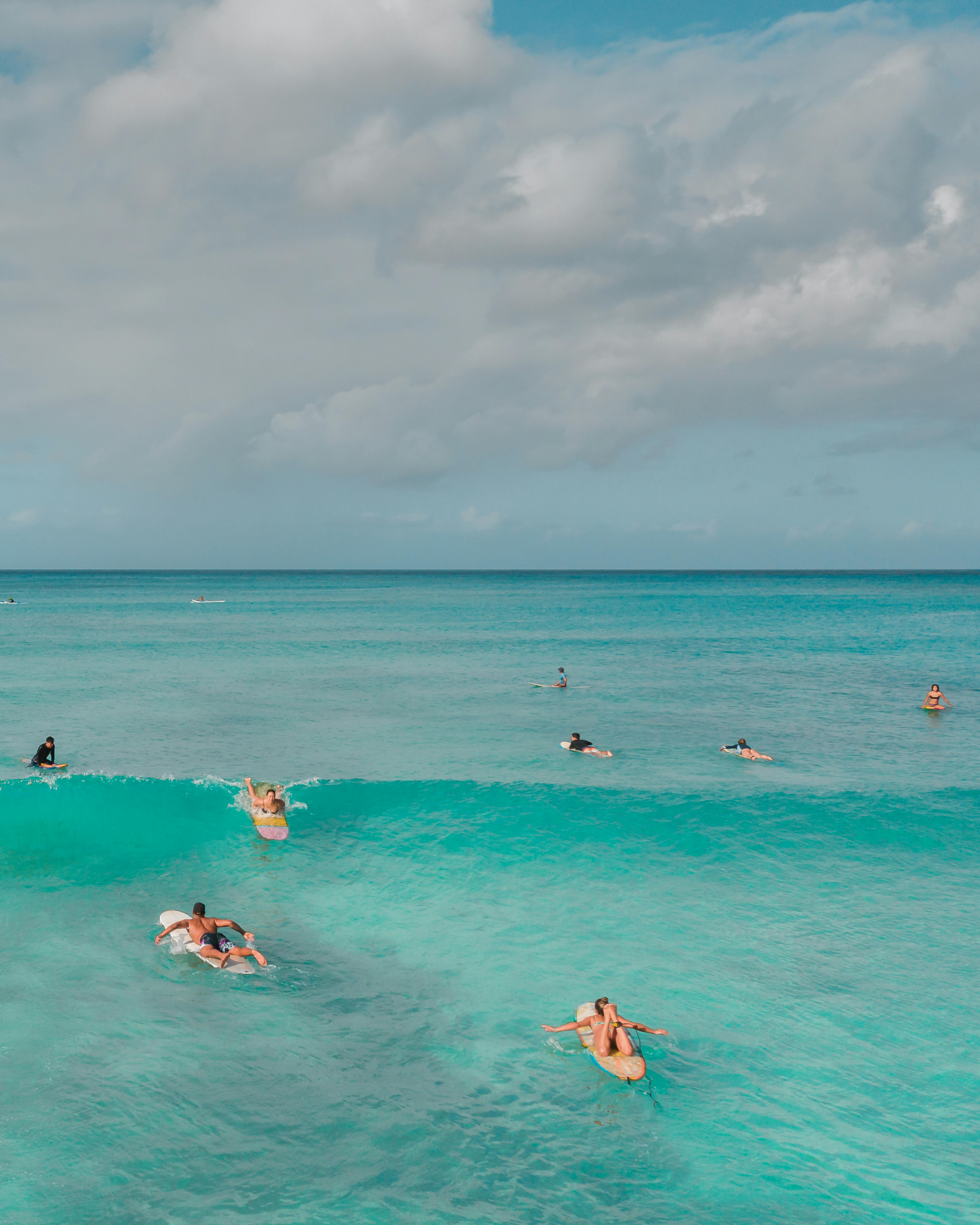 Idyllic View of People Surfboarding in a Turquoise Sea · Free Stock Photo