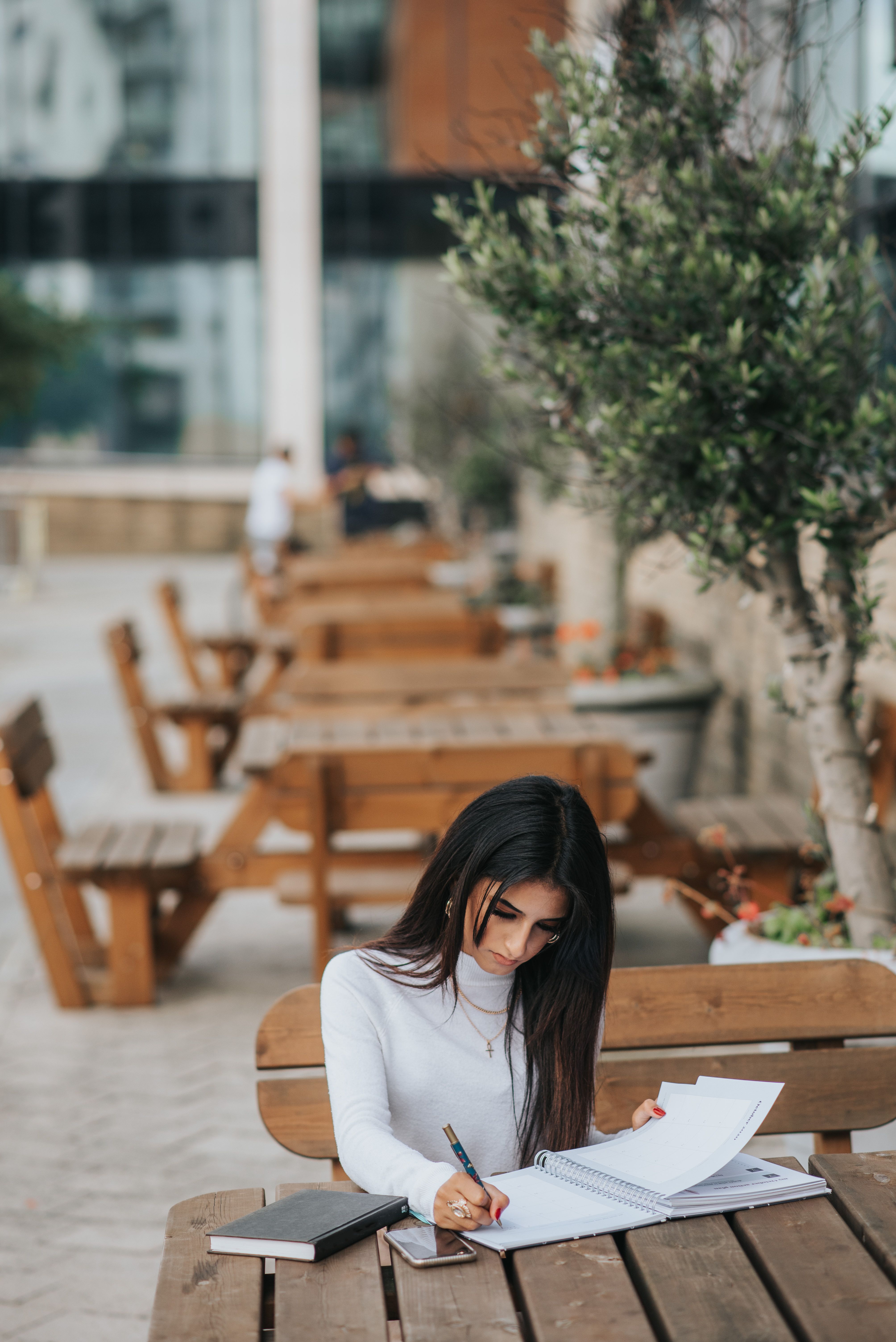 Crop office employee taking notes in notebook at table · Free Stock Photo