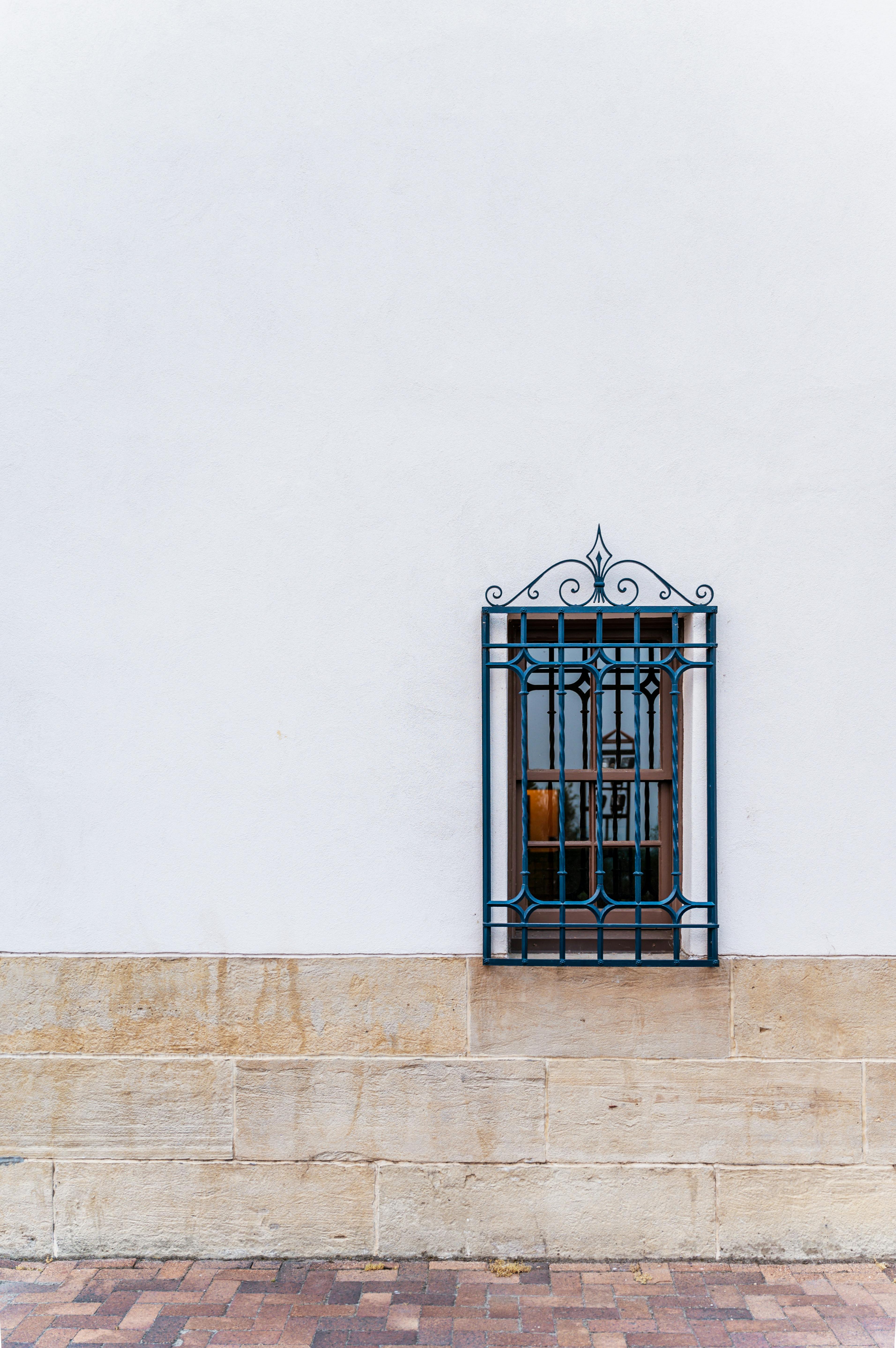 Window behind bars on white wall · Free Stock Photo
