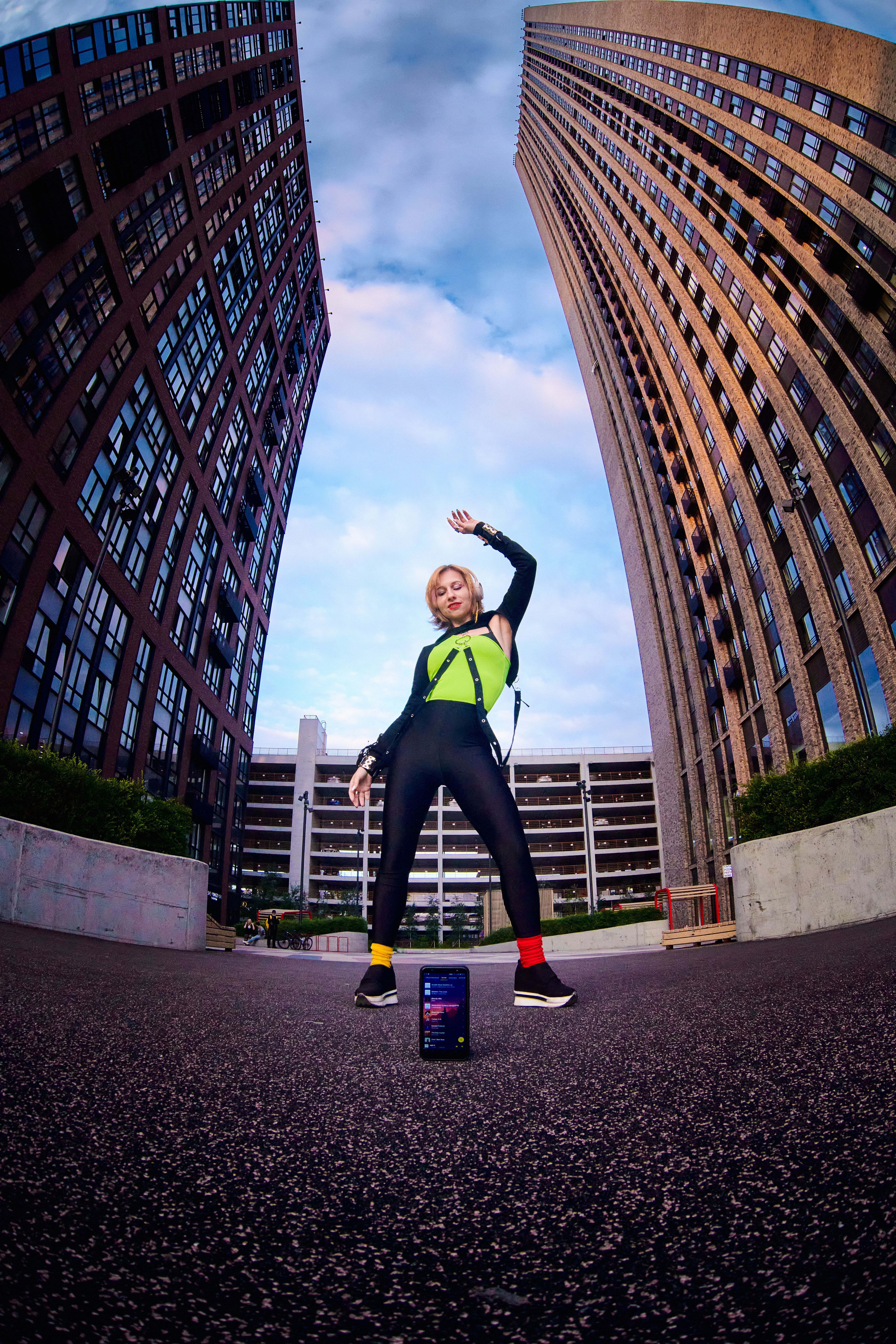 Trendy woman standing against tall buildings · Free Stock Photo