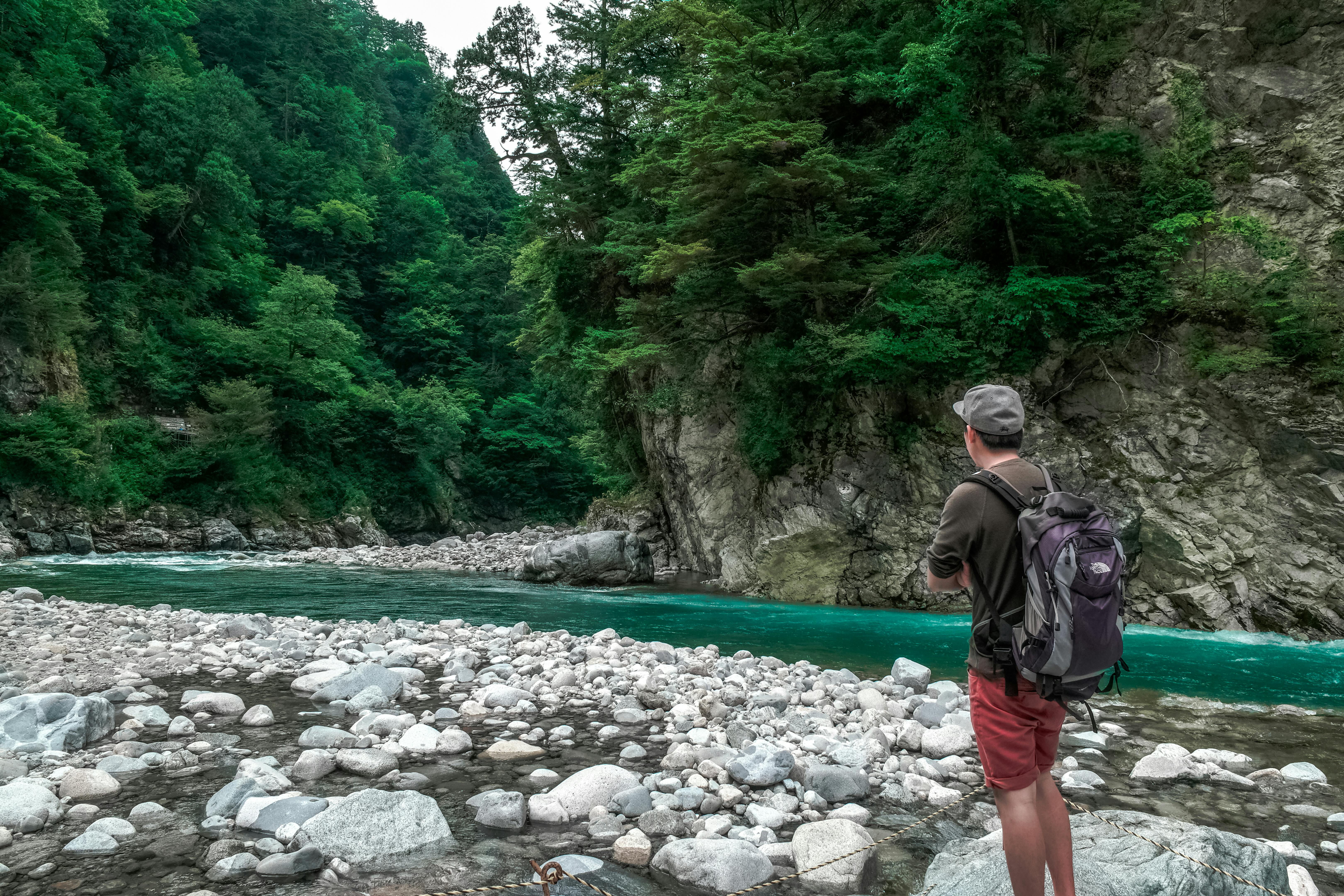 Man Staring at Flow of Water Outdoors · Free Stock Photo