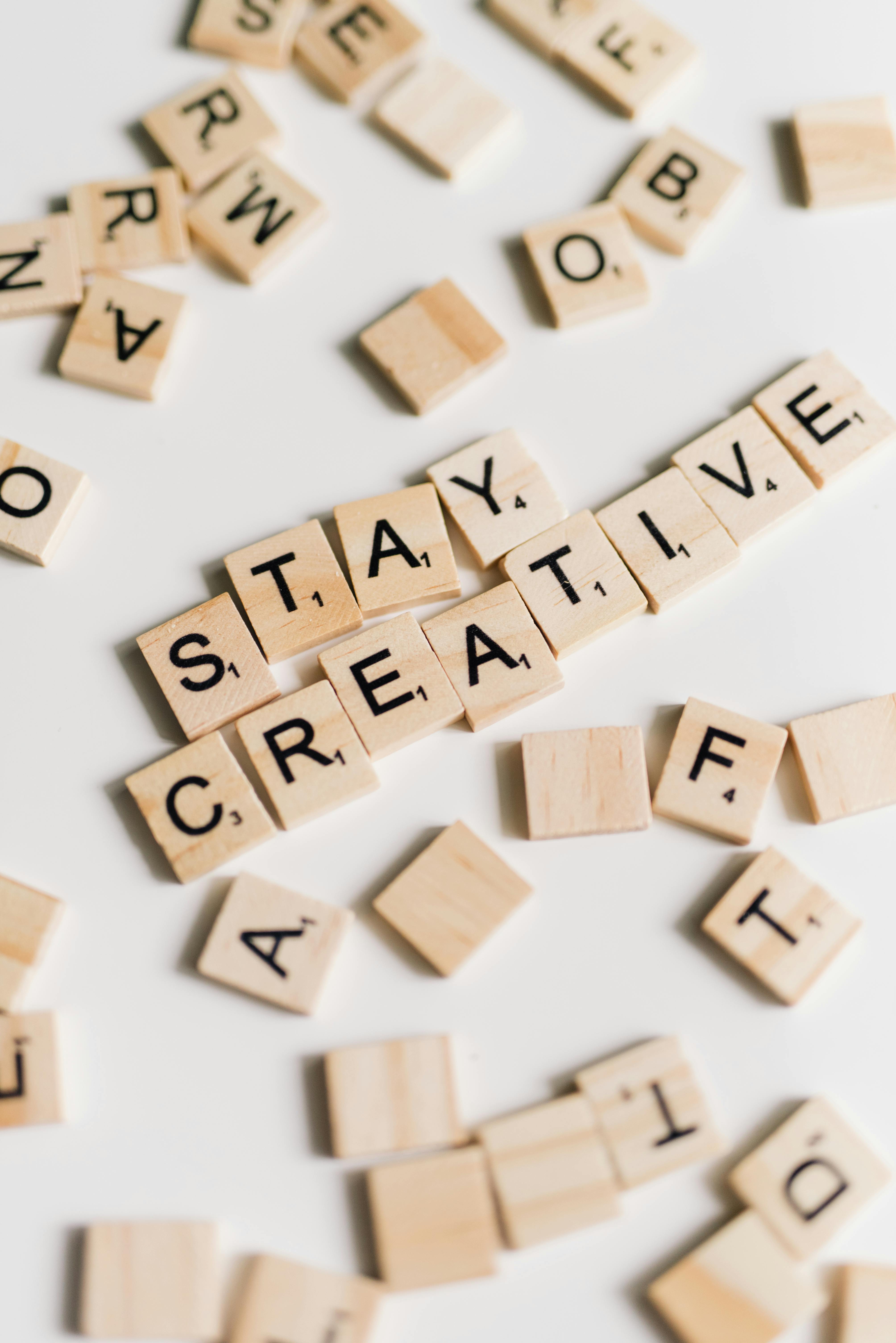 Close-Up Shot of Scrabble Tiles on a White Surface · Free Stock Photo