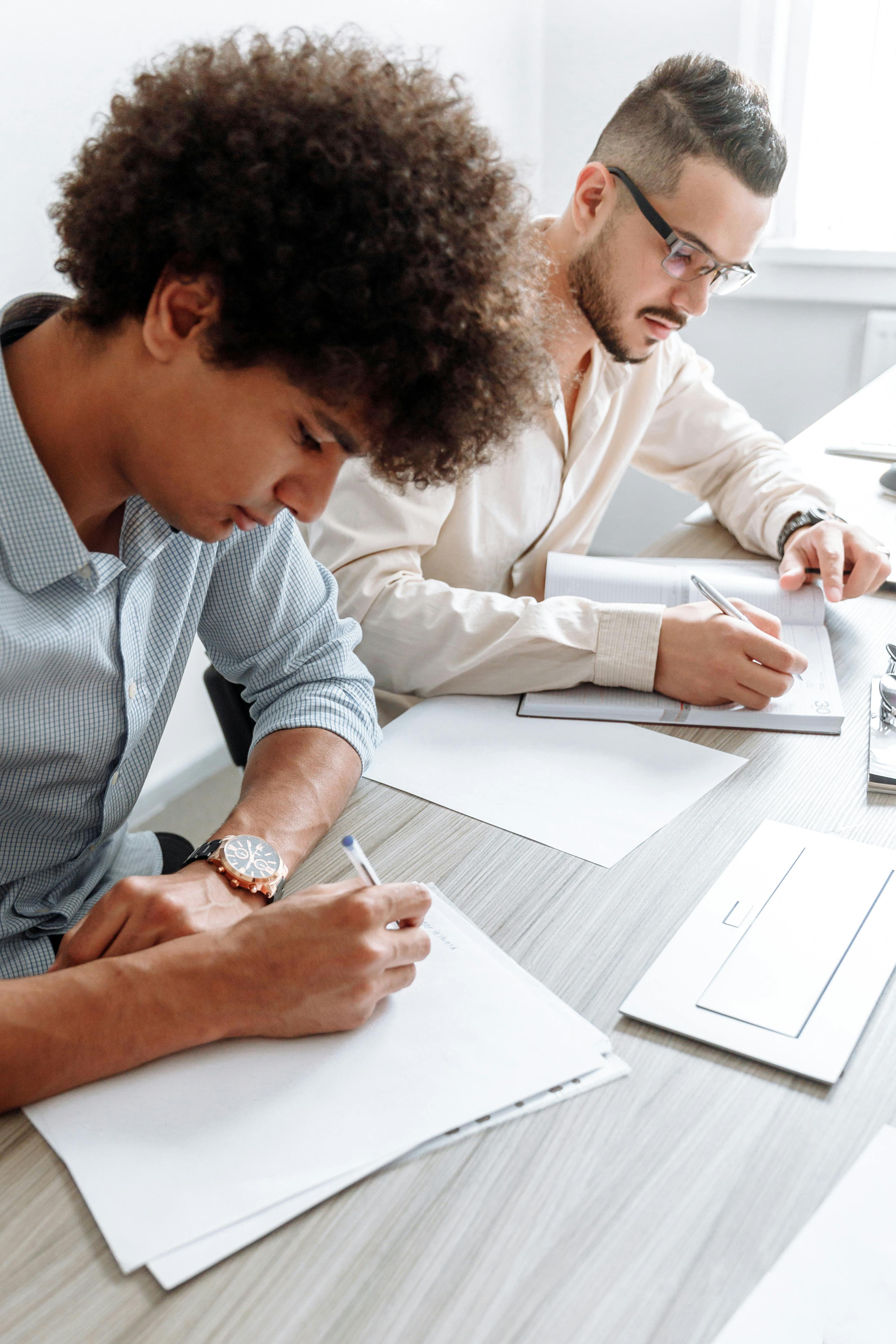 Men Writing on Documents · Free Stock Photo