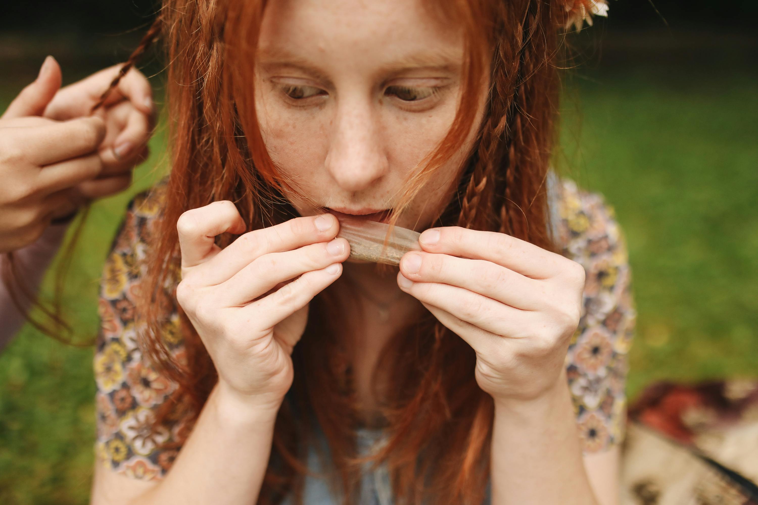 Woman Licking a Rolling Paper · Free Stock Photo