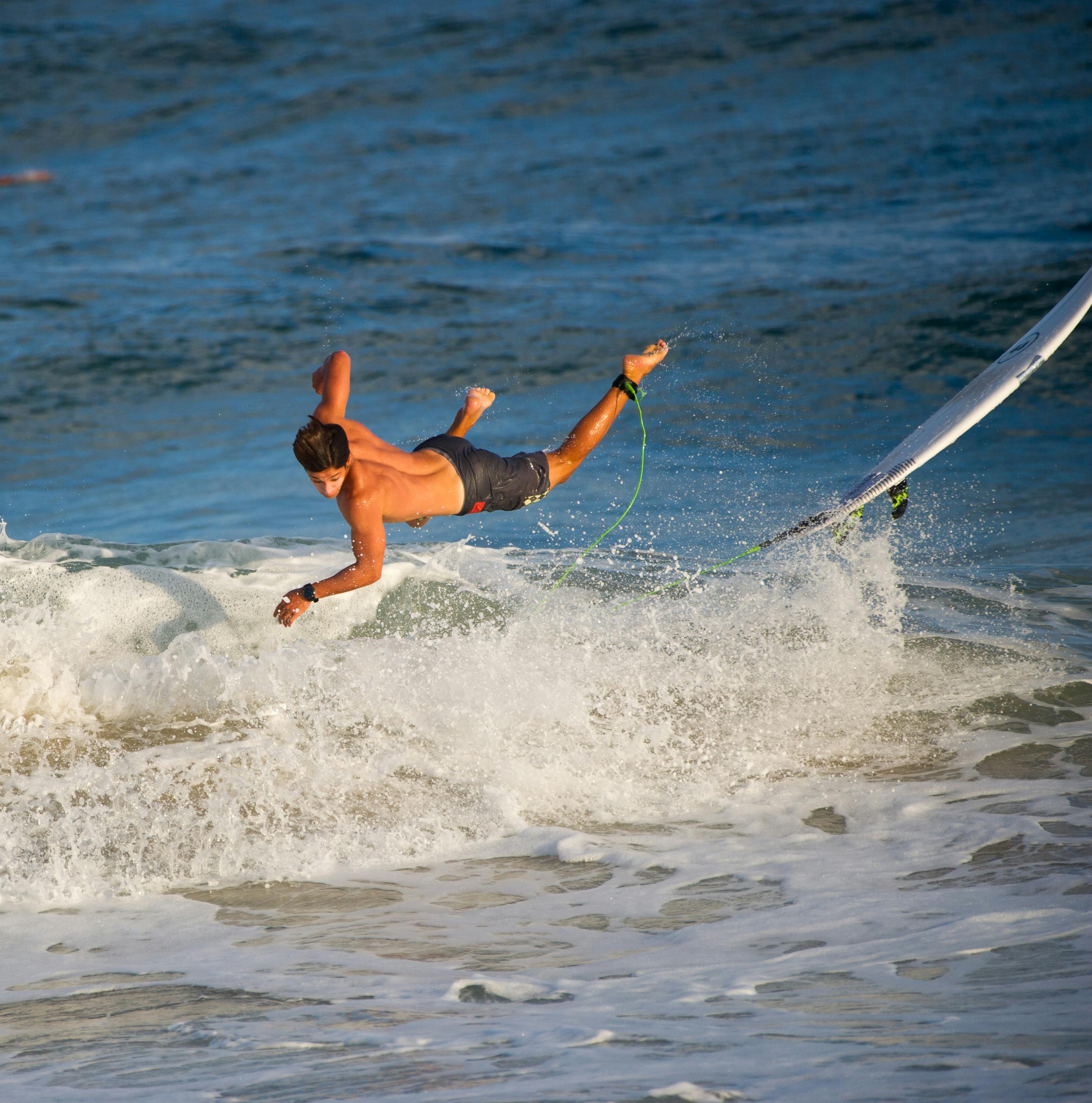 A Man Falling Off a Surfboard · Free Stock Photo