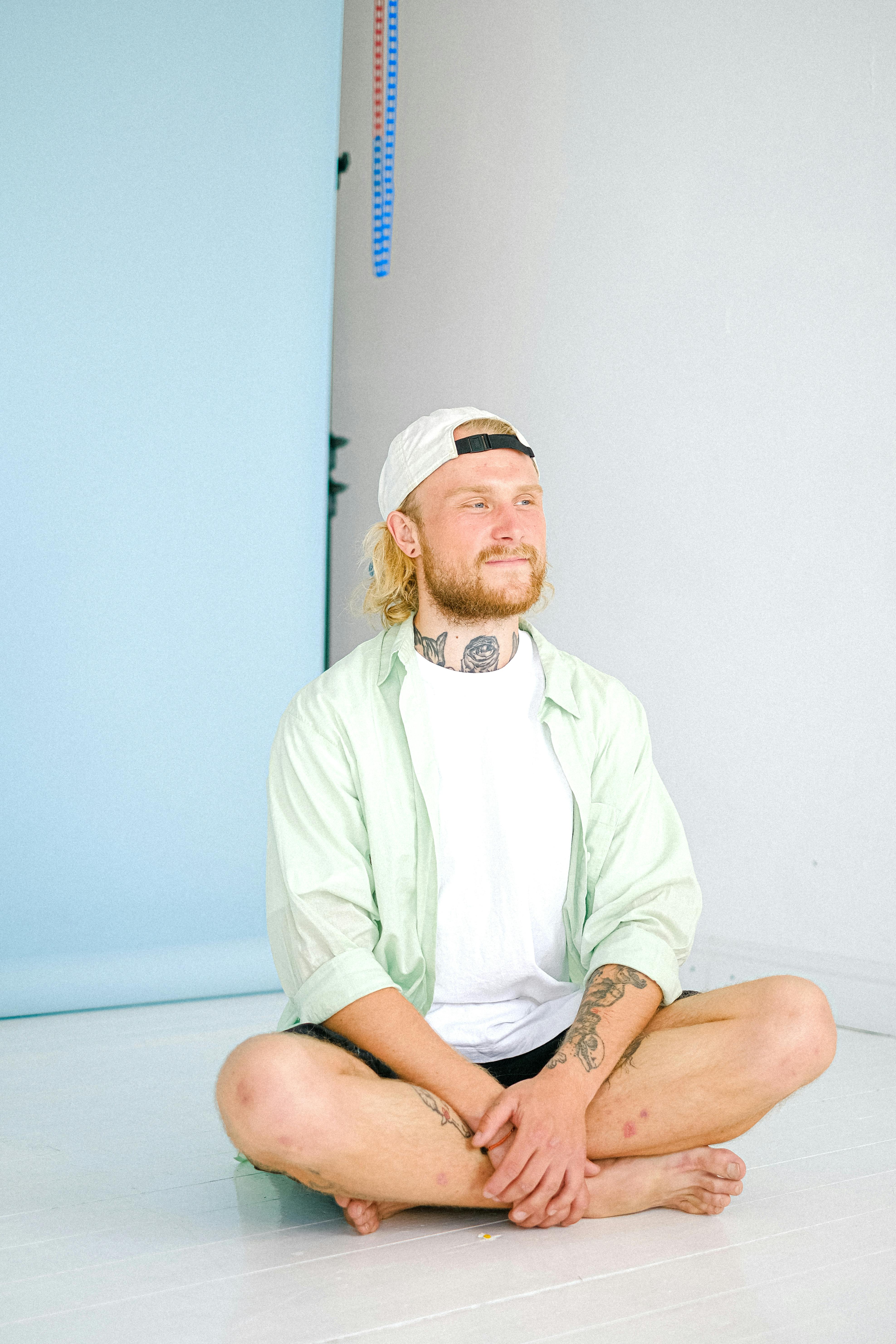 Dreamy hipster man in cap resting on floor · Free Stock Photo