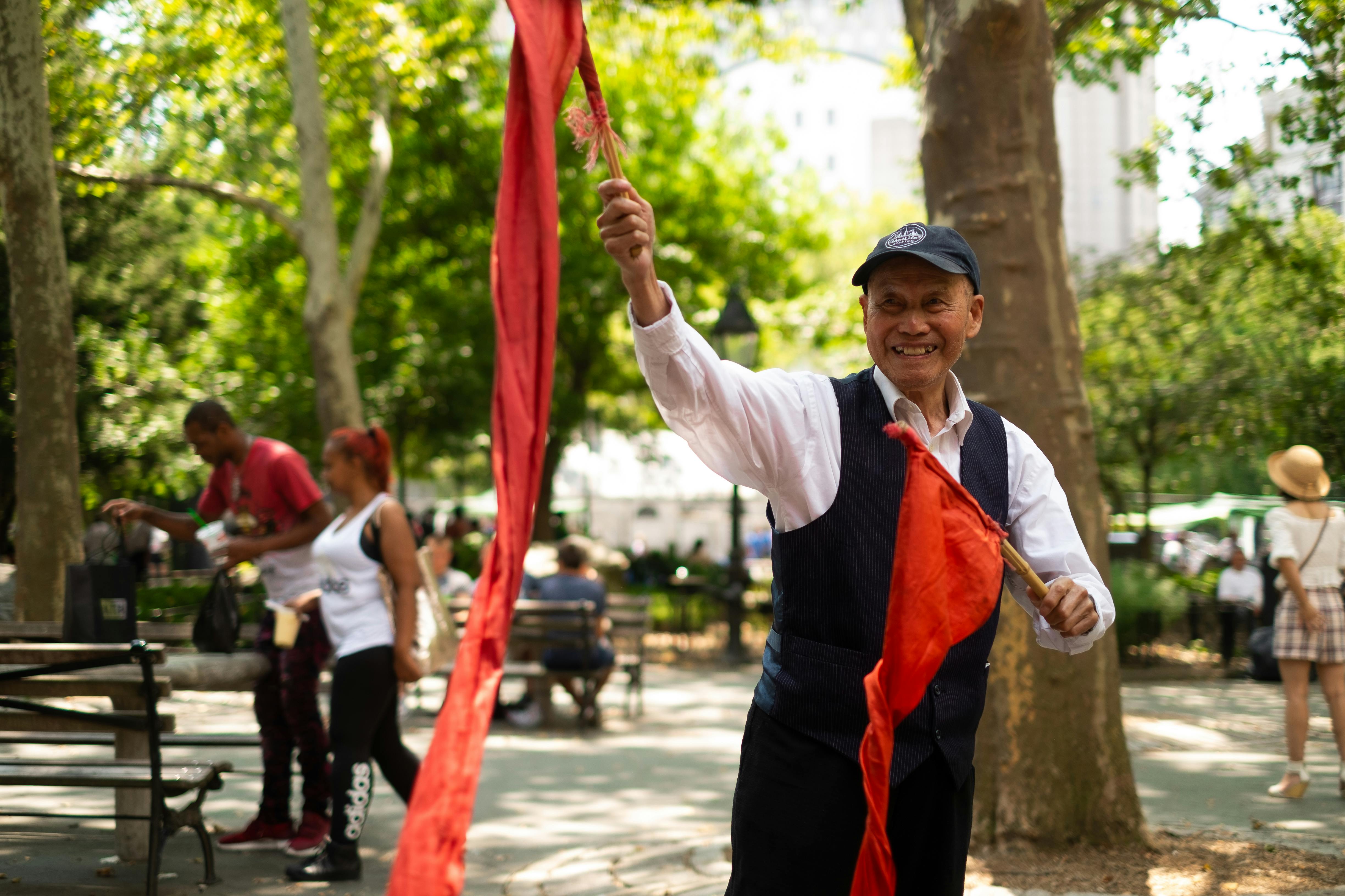 An Elderly Man Holding Red Flags · Free Stock Photo