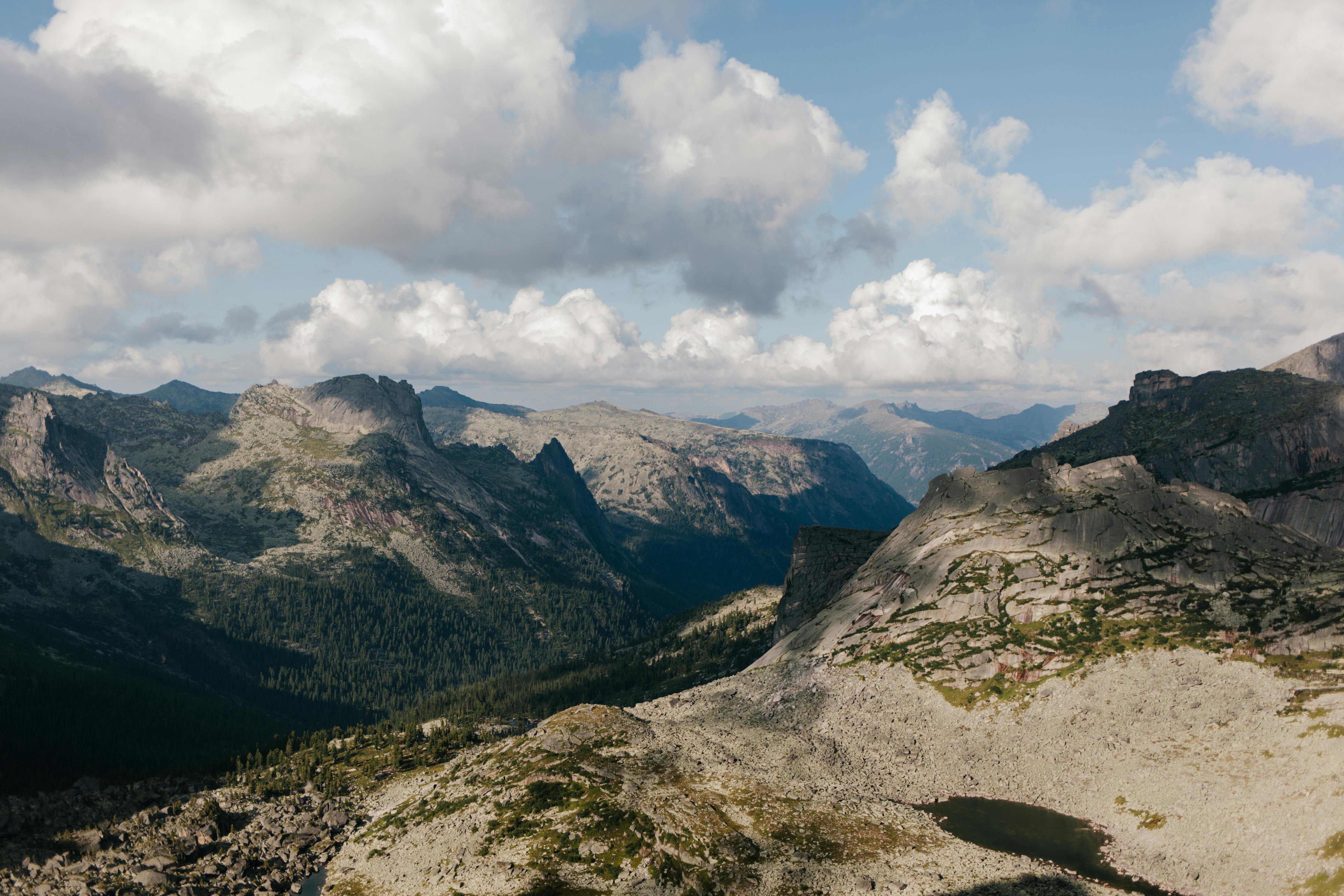 High rocky rough mountains under blue cloudy sky · Free Stock Photo