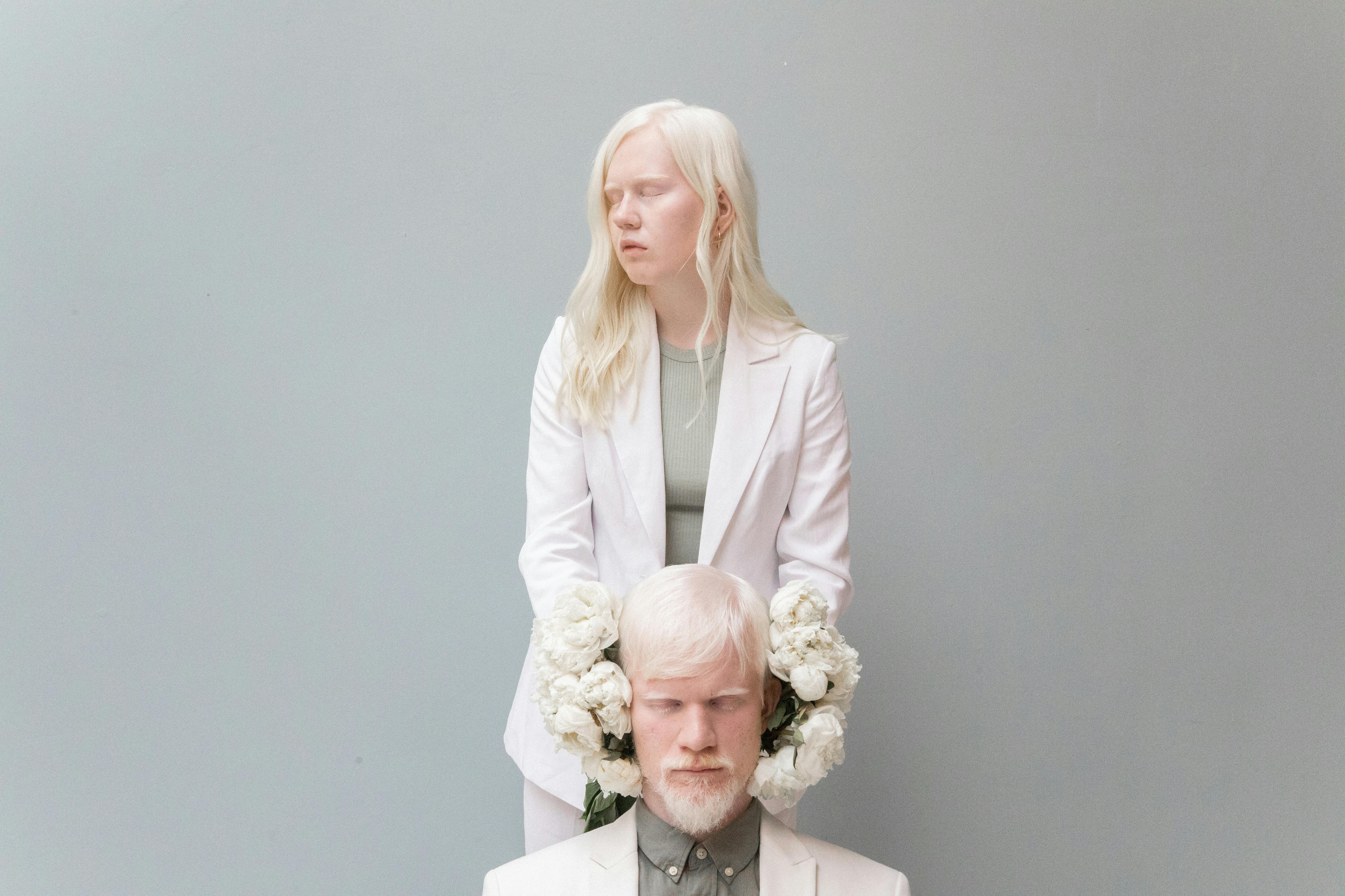 Elegant albino couple with flowers in studio · Free Stock Photo