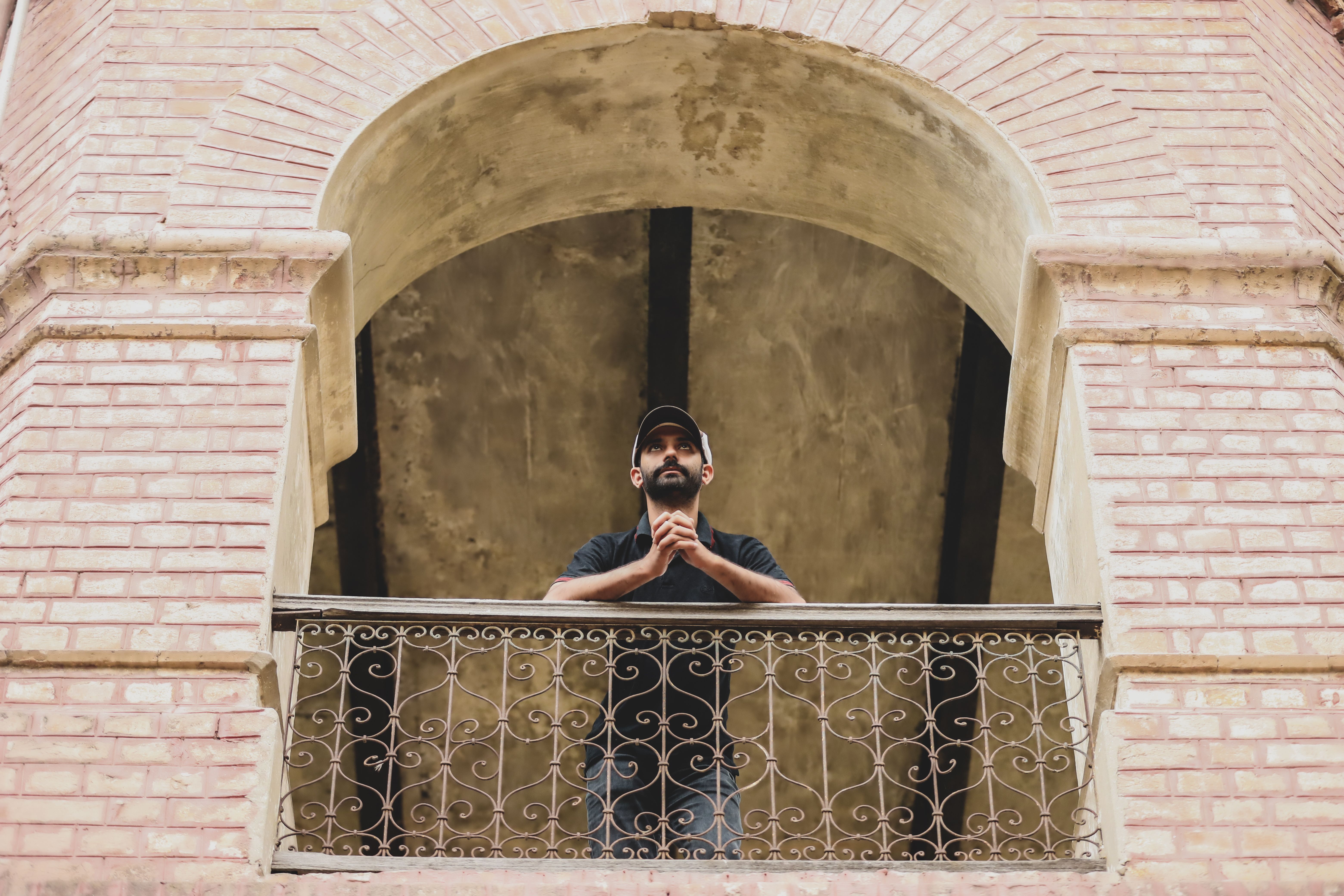 Man Standing on Balcony of Ancient Building · Free Stock Photo