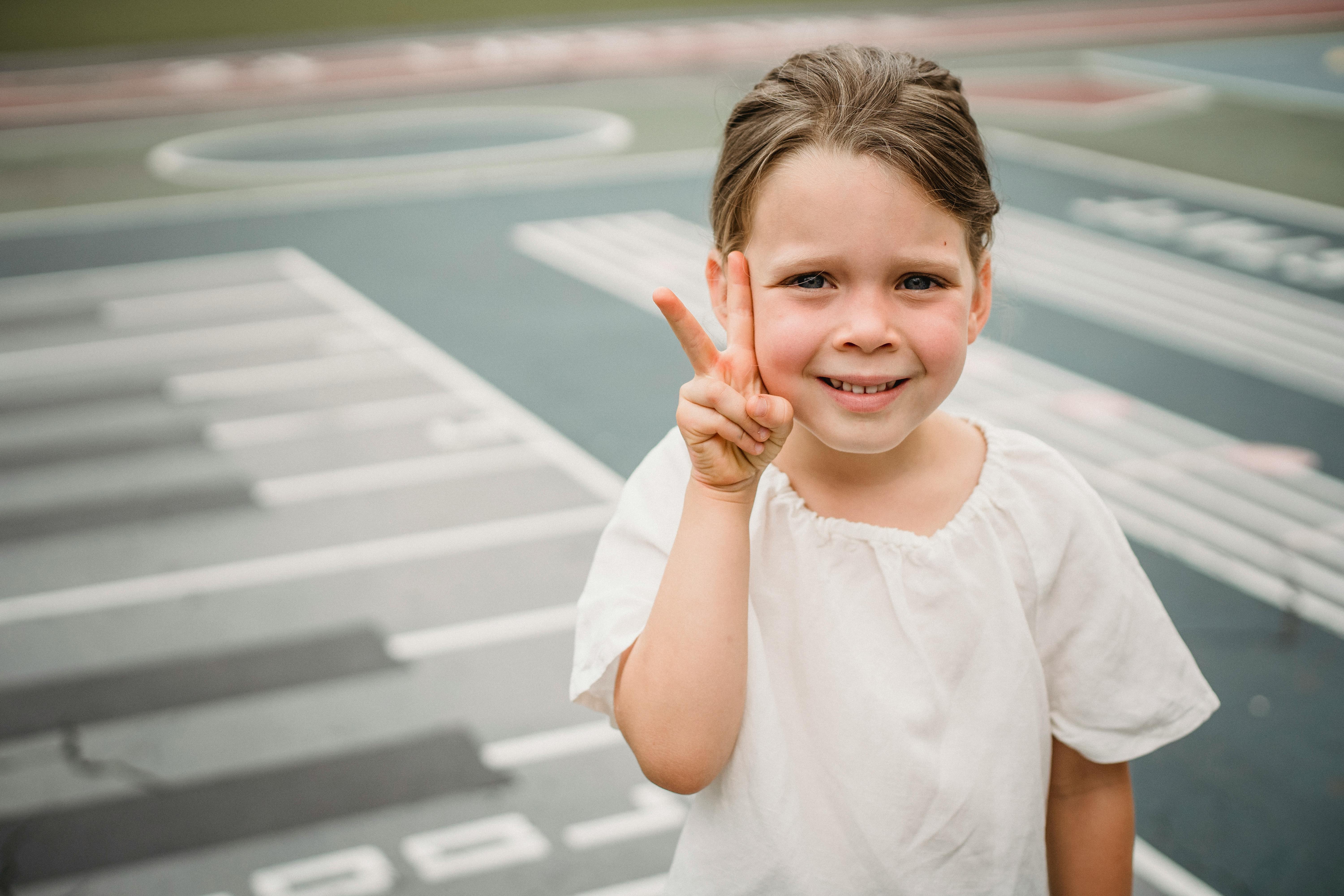 A Girl Making a Peace Sign · Free Stock Photo