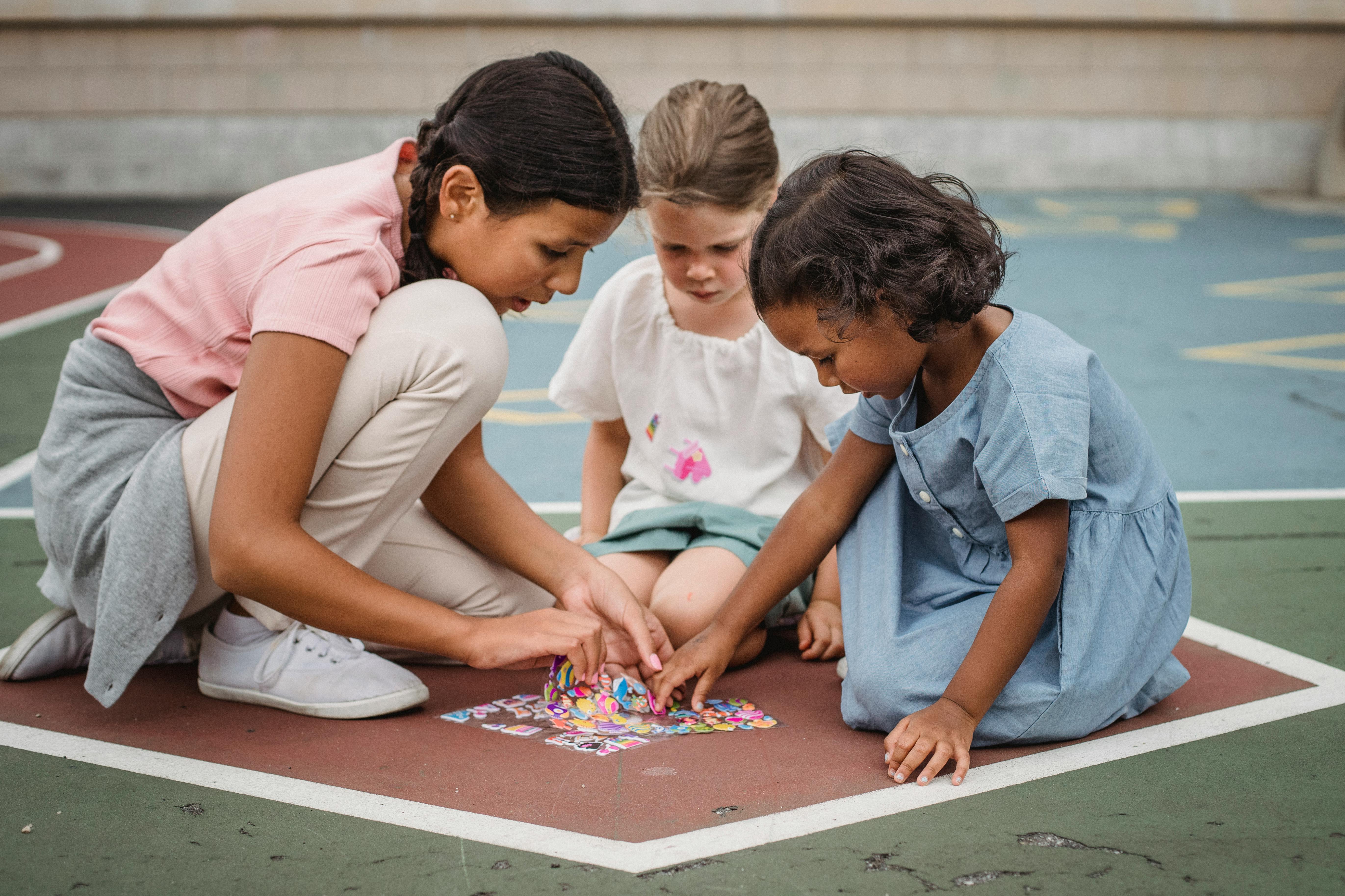 Photo of Children Playing with Stickers Outdoors · Free Stock Photo