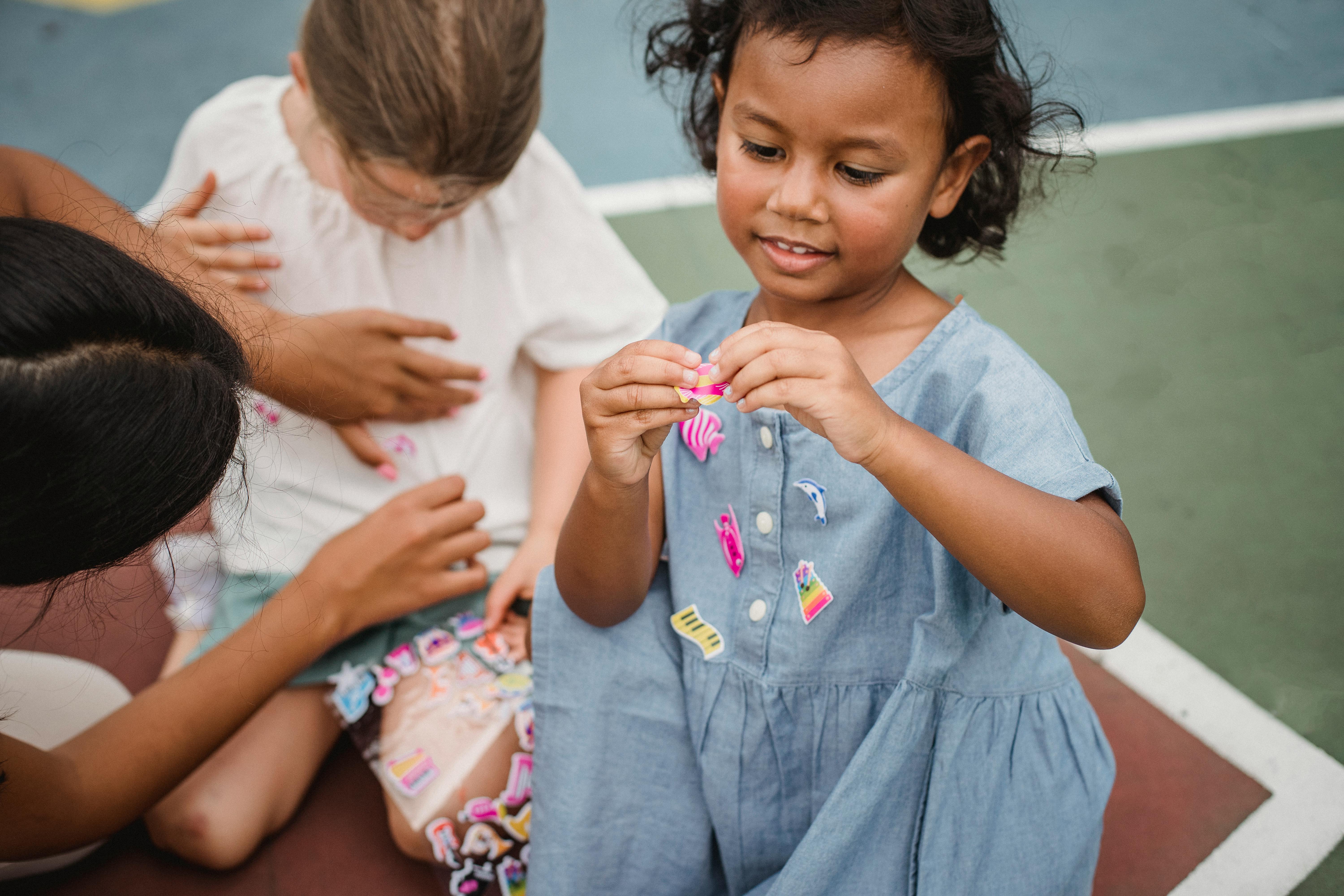 Photo of Children Playing with Stickers Outdoors · Free Stock Photo