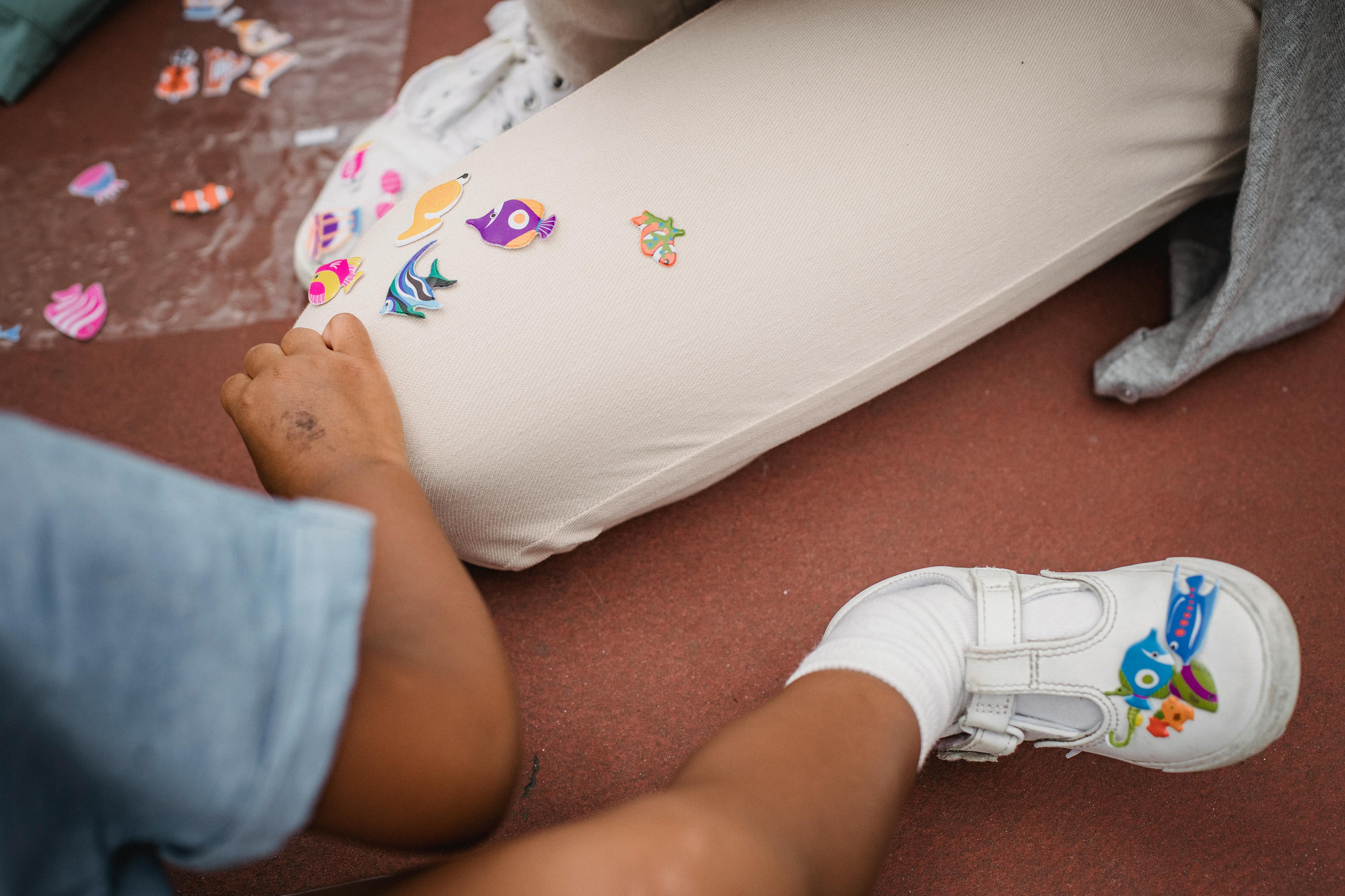 Child Playing with Colorful Stickers · Free Stock Photo