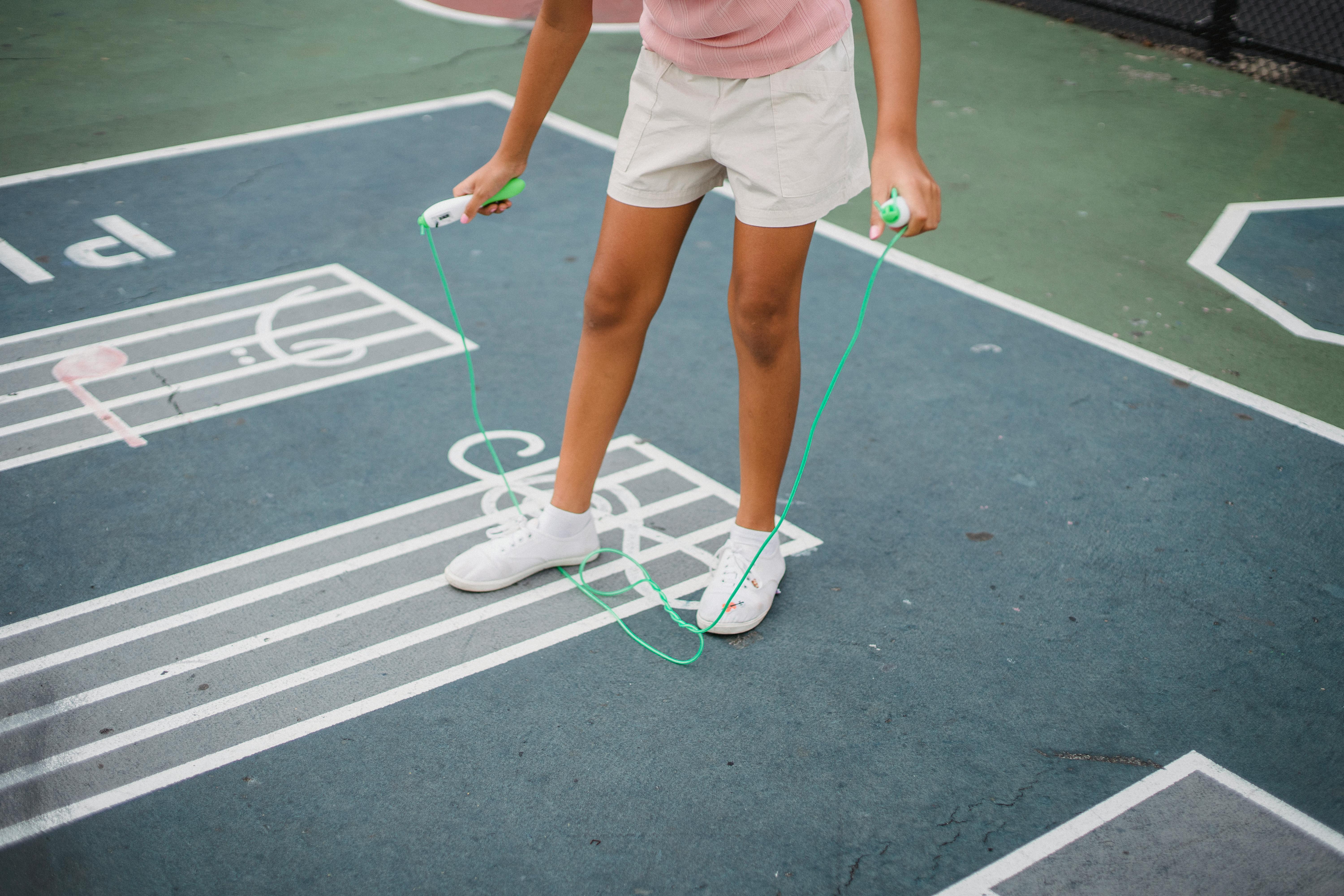 Woman in Pink Tank Top and White Shorts Stepping on a Jump Rope · Free ...