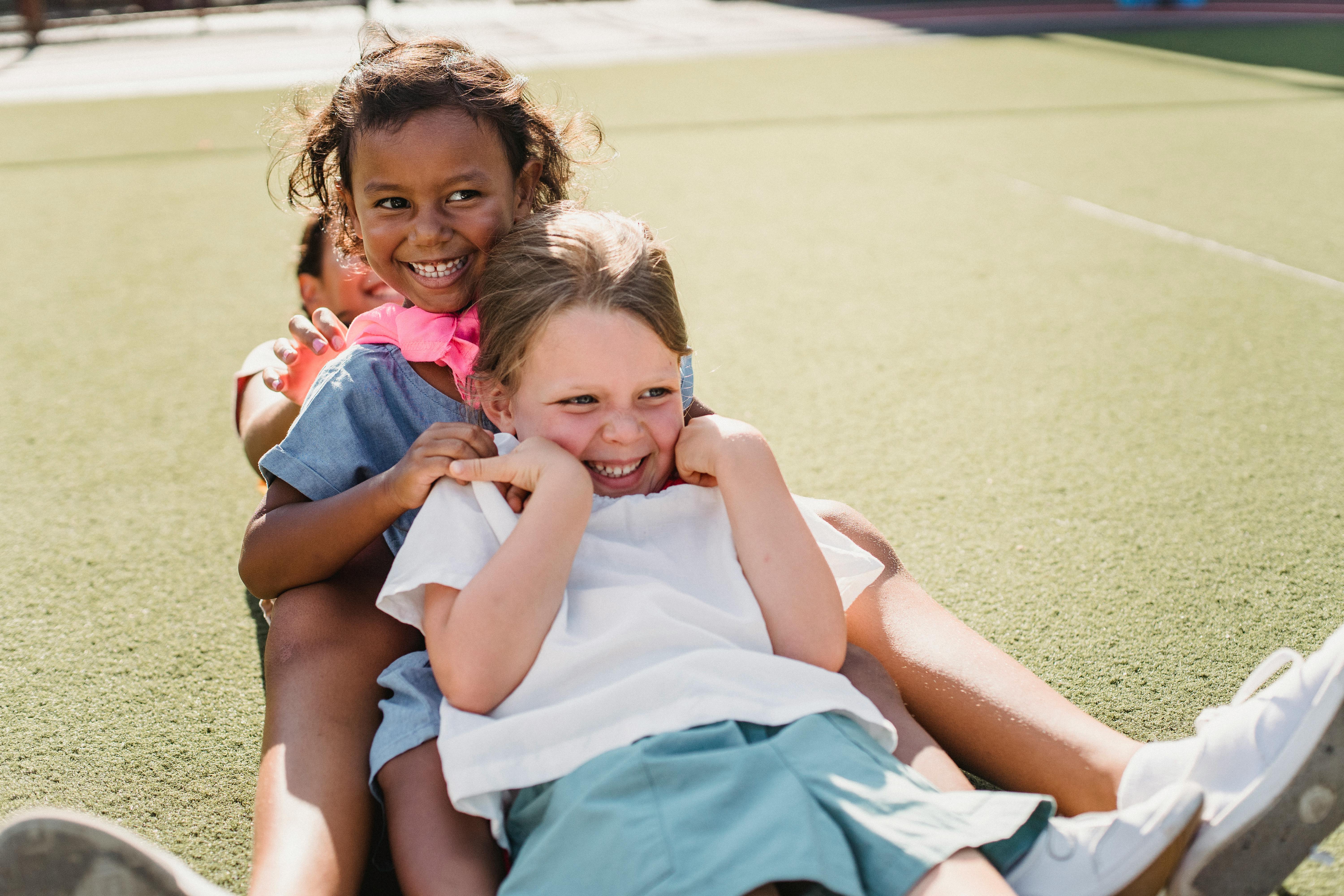 Kids Sitting Behind Each Other on Grass and Laughing · Free Stock Photo
