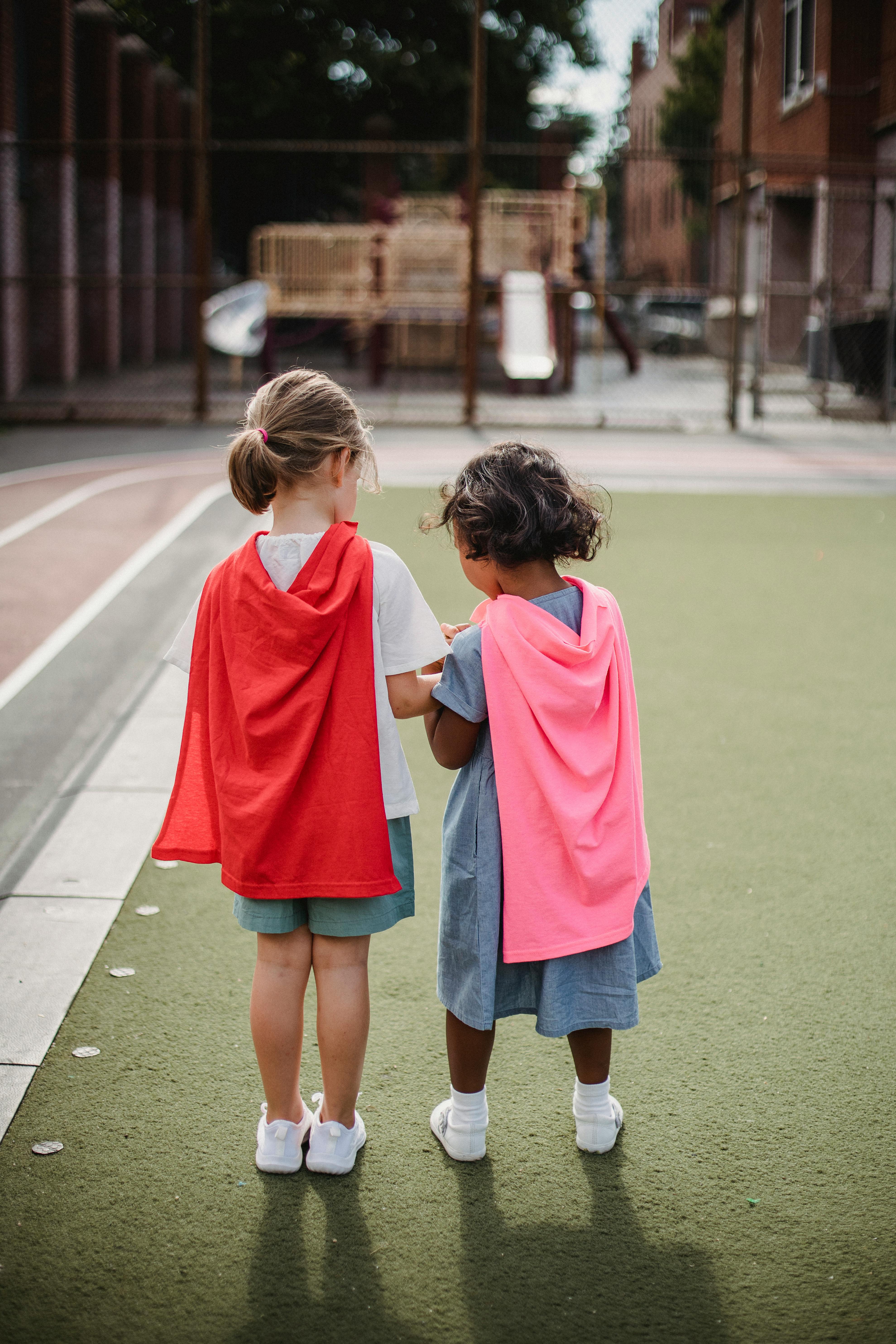 Little Girls Wearing Capes and Holding Hands · Free Stock Photo