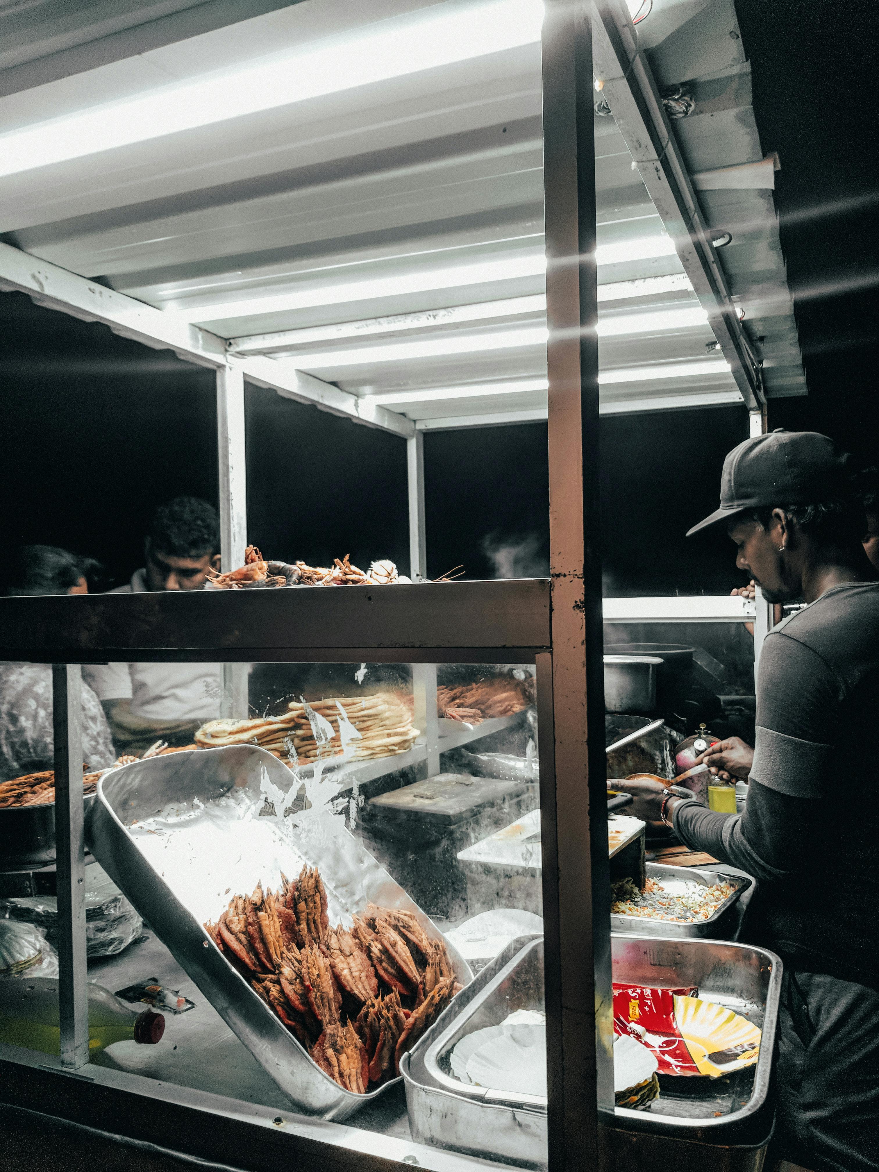 Man Wearing a Cap Selling Street Food · Free Stock Photo