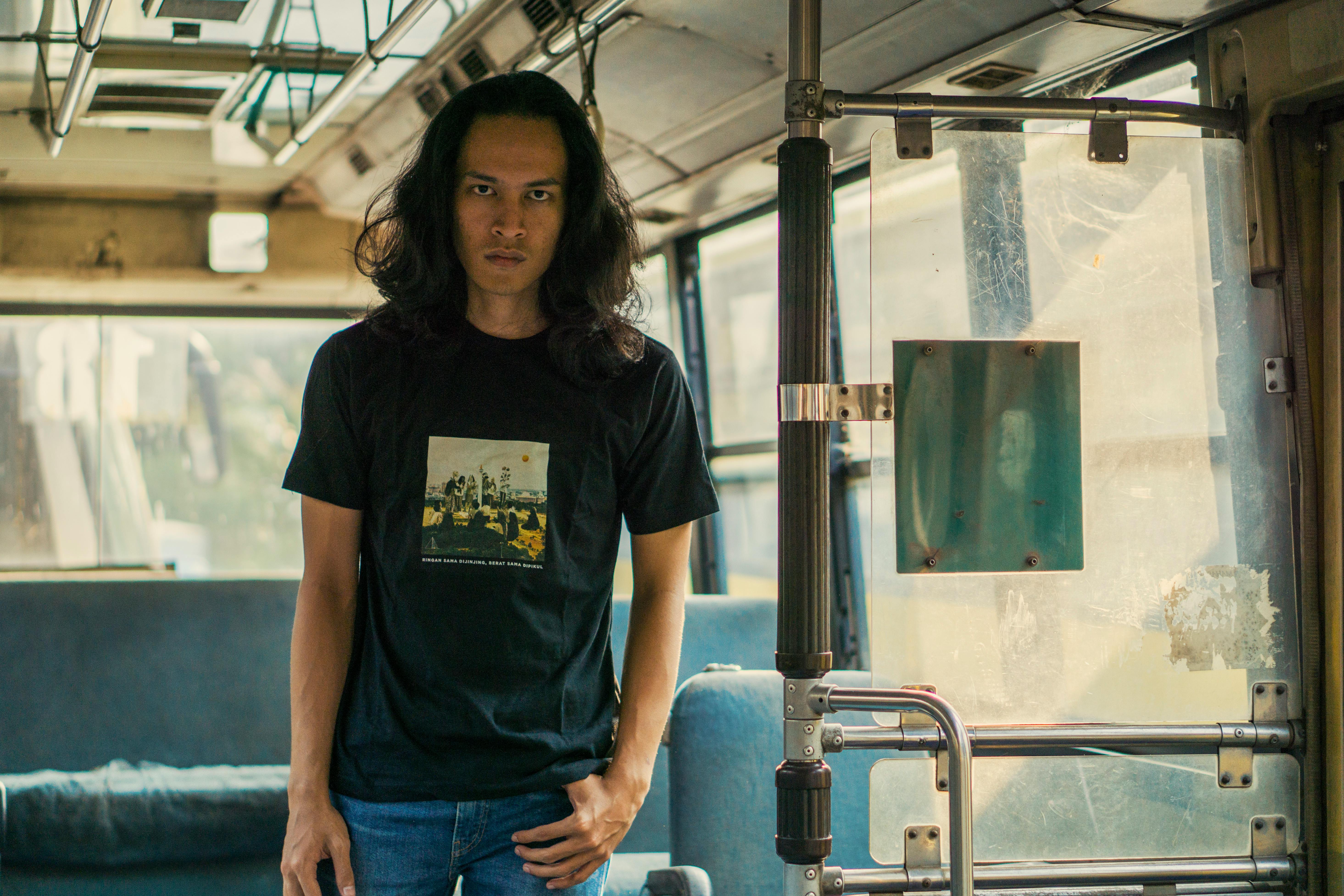 A Man in Black Shirt Standing Inside the Bus · Free Stock Photo
