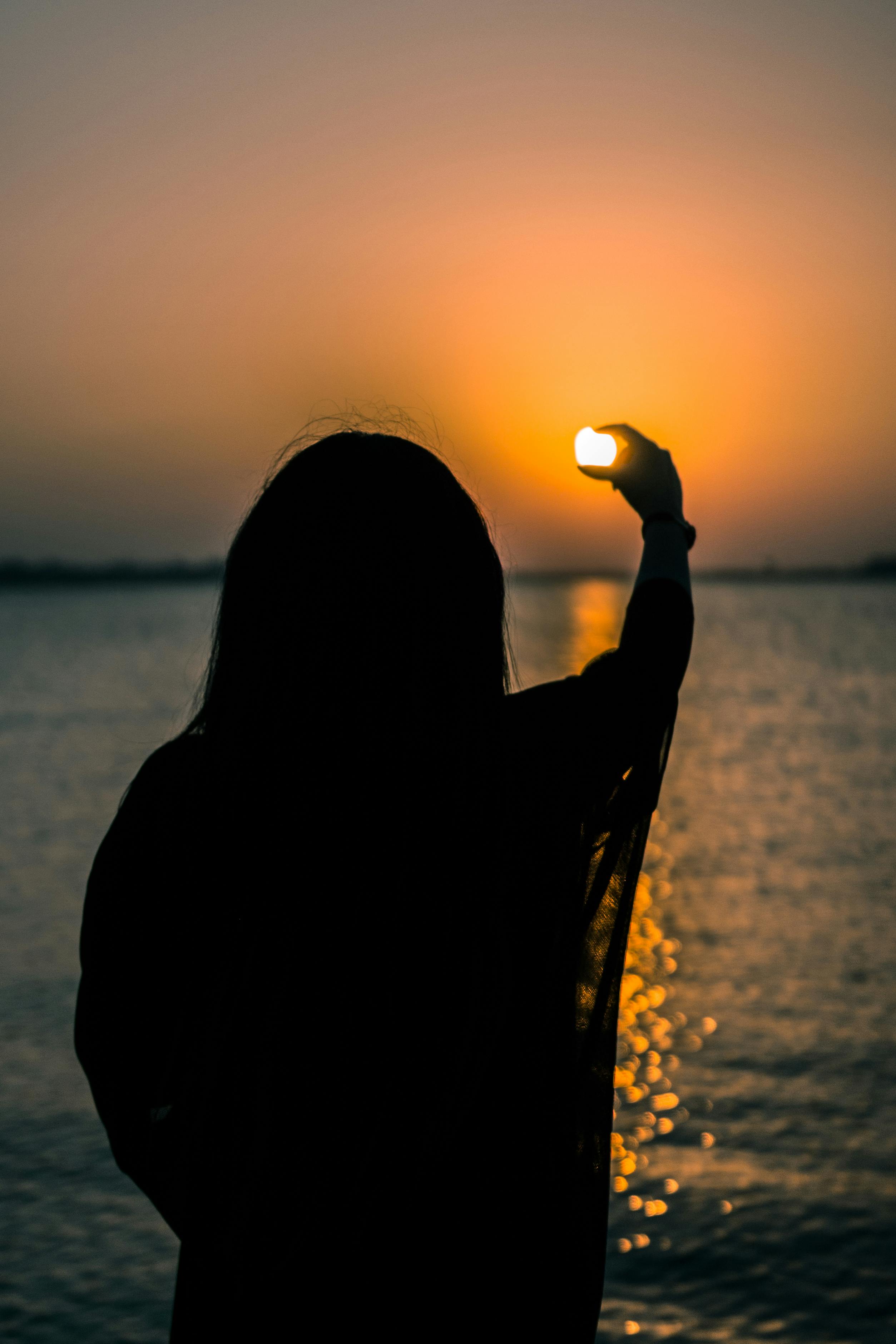 Person Holding Setting Sun with Fingers · Free Stock Photo