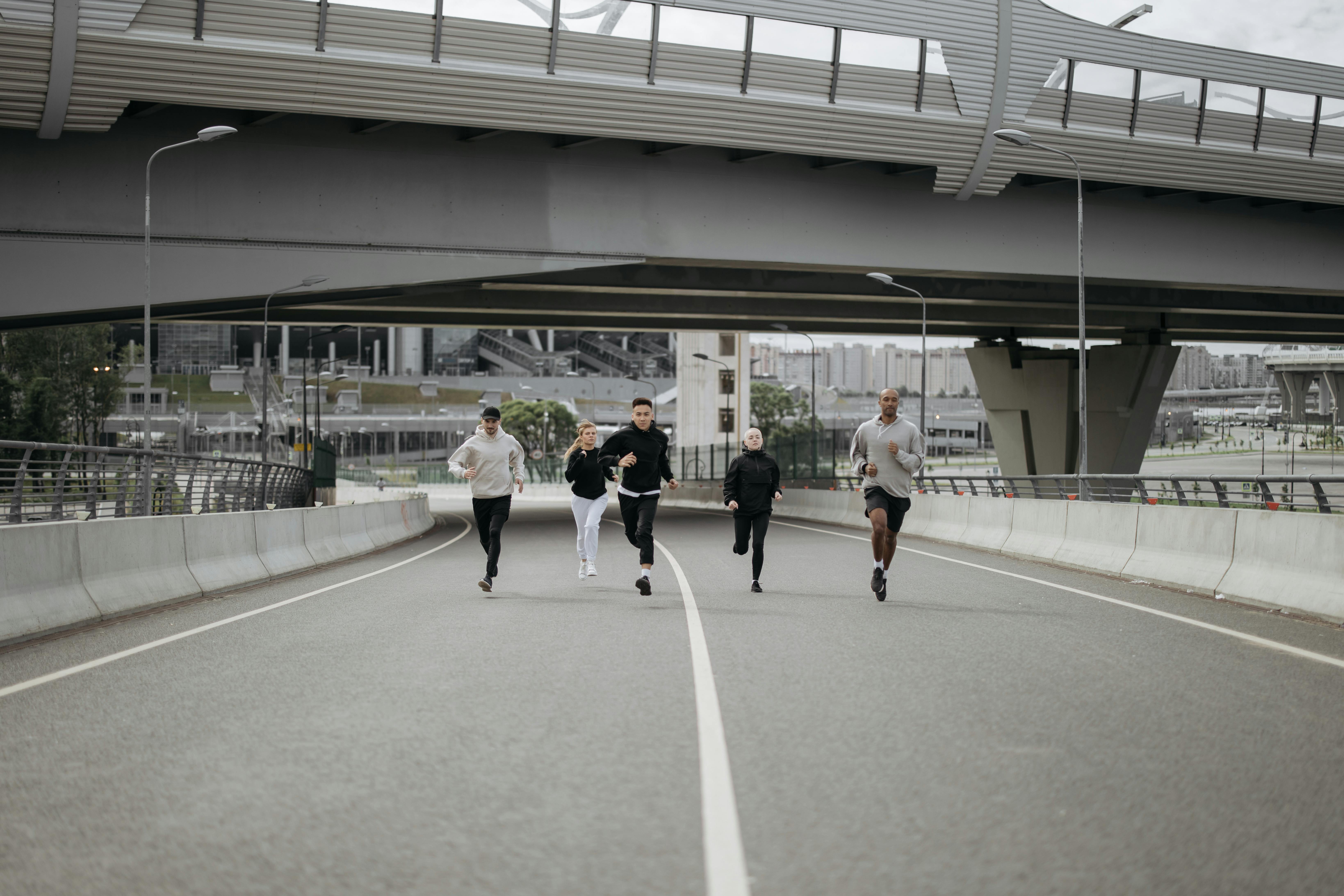 People Running on the Road Under a Cloudy Sky · Free Stock Photo