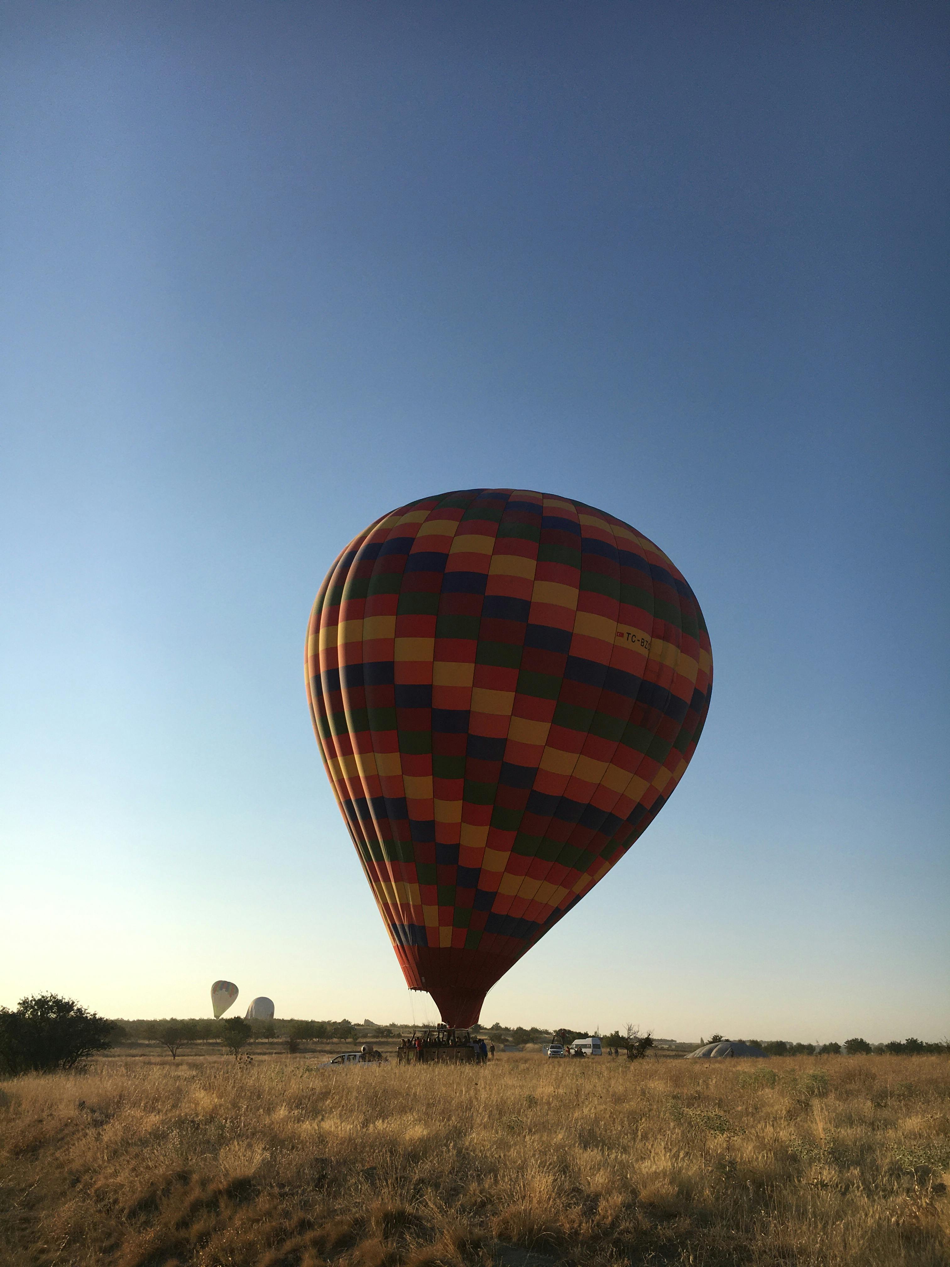 Grass Field and Hot Air Balloon against Blue Sky · Free Stock Photo