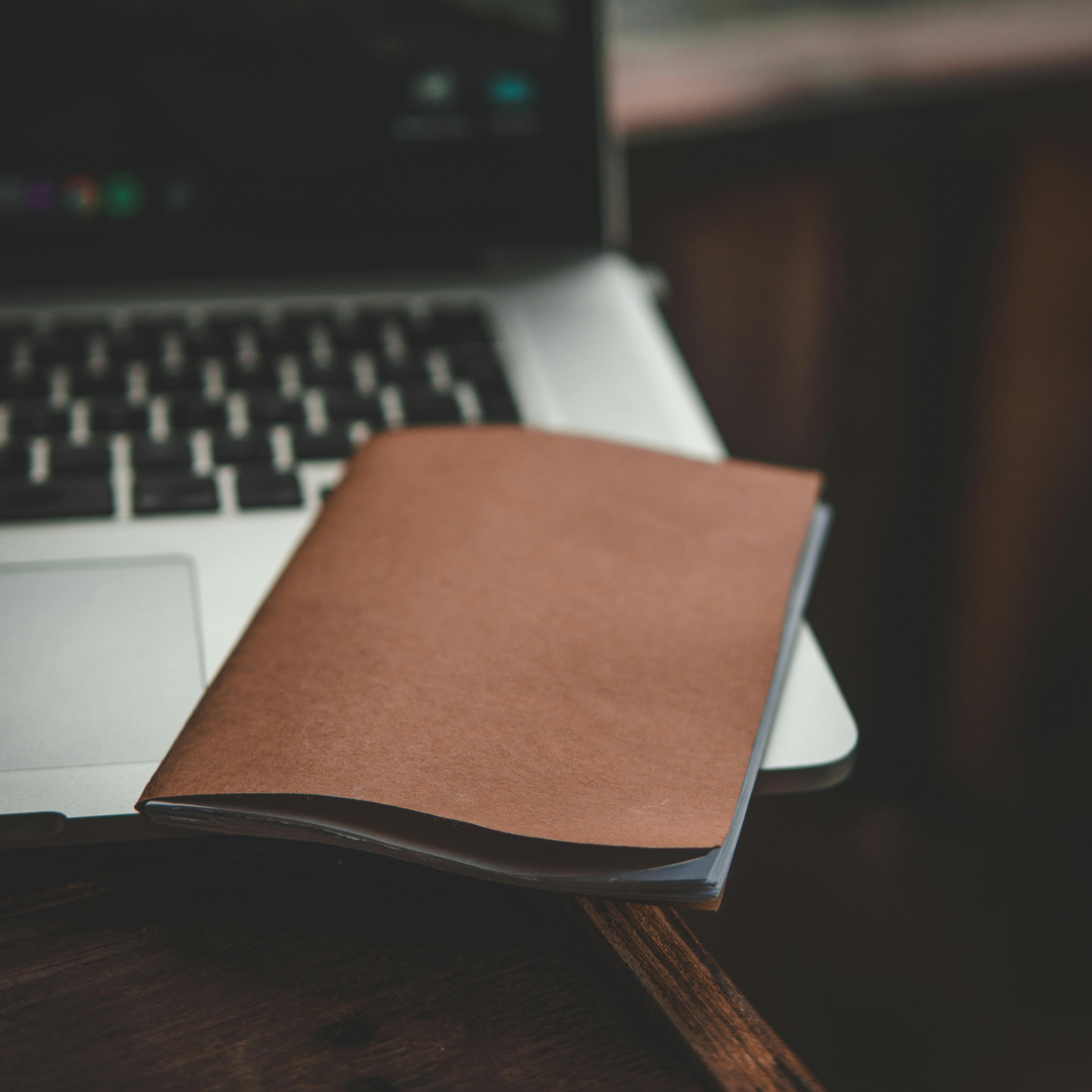 Brown Notebook on the Laptop · Free Stock Photo