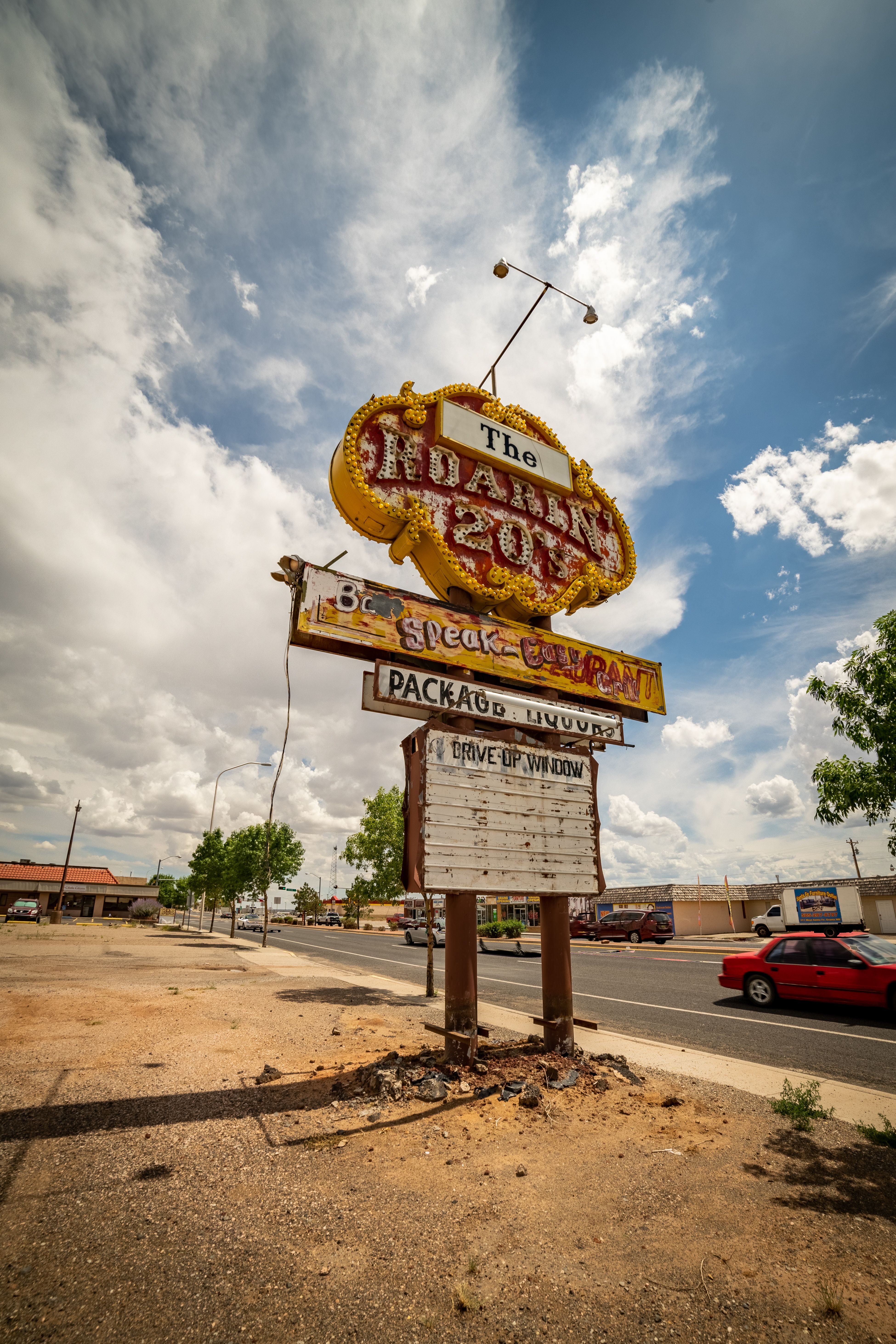Signage on Dirt Ground Along an Asphalt Road · Free Stock Photo