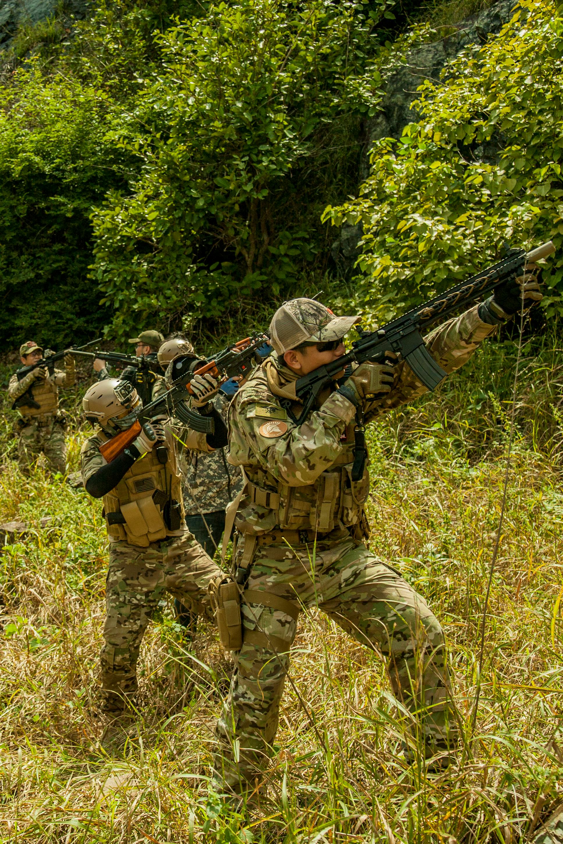 Soldiers Standing in Tall Grass next to Trees Holding Rifles Up · Free ...