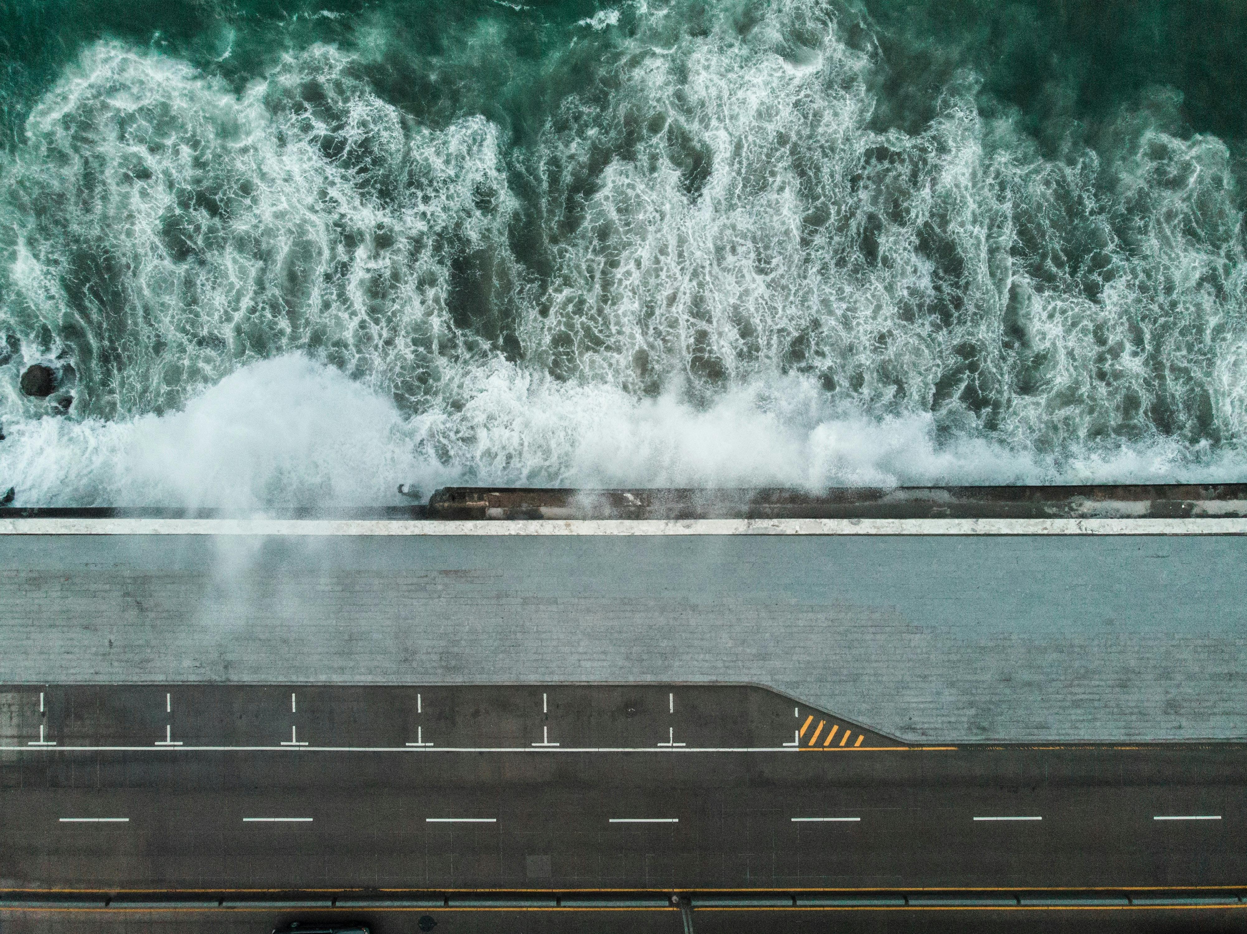 Top View of Waves Crashing Into a Bridge · Free Stock Photo