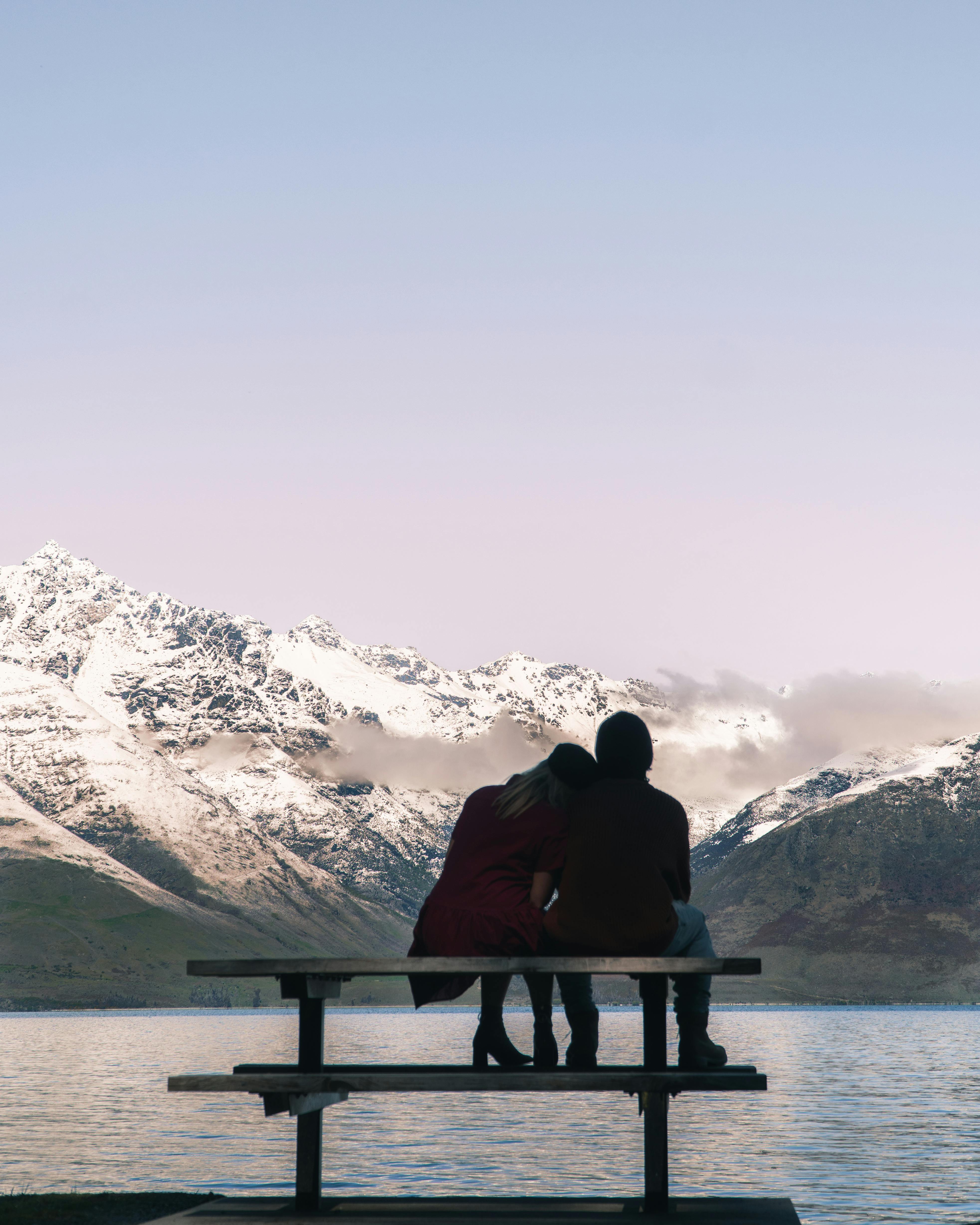 Romantic couple sitting on bench and admiring lake and mountains · Free ...