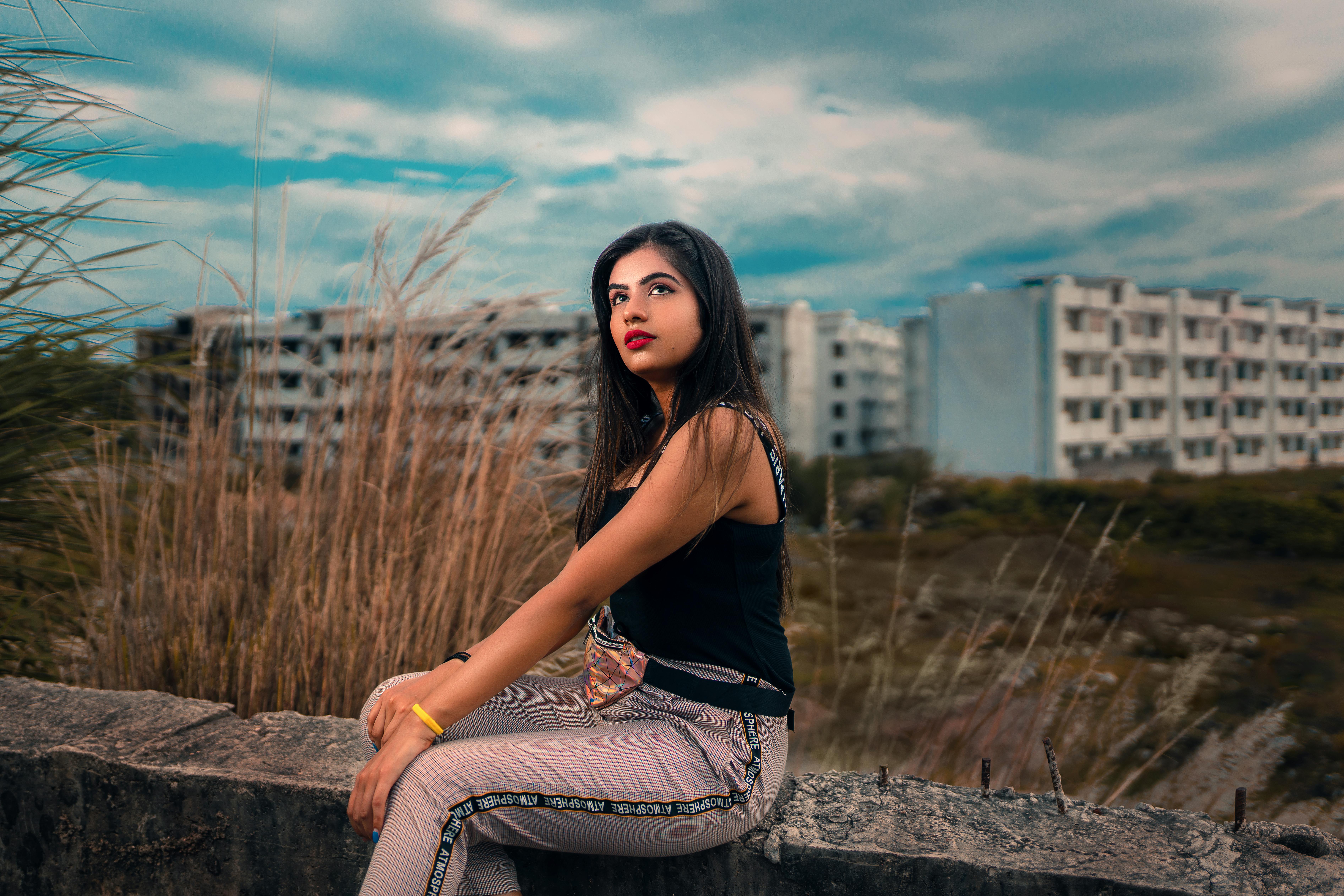 A Beautiful Woman Sitting on a Ledge · Free Stock Photo