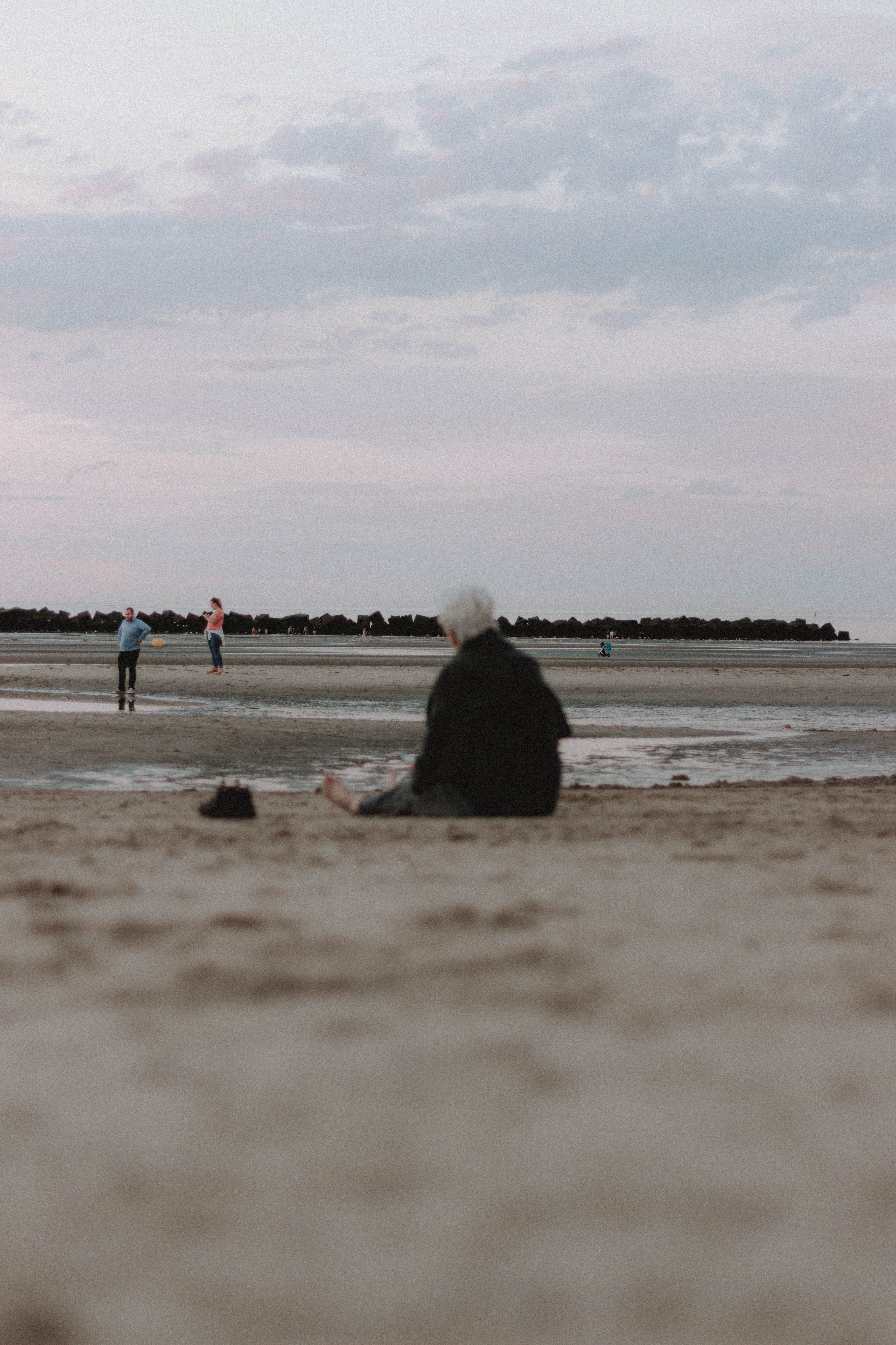 Person sitting on sandy beach · Free Stock Photo